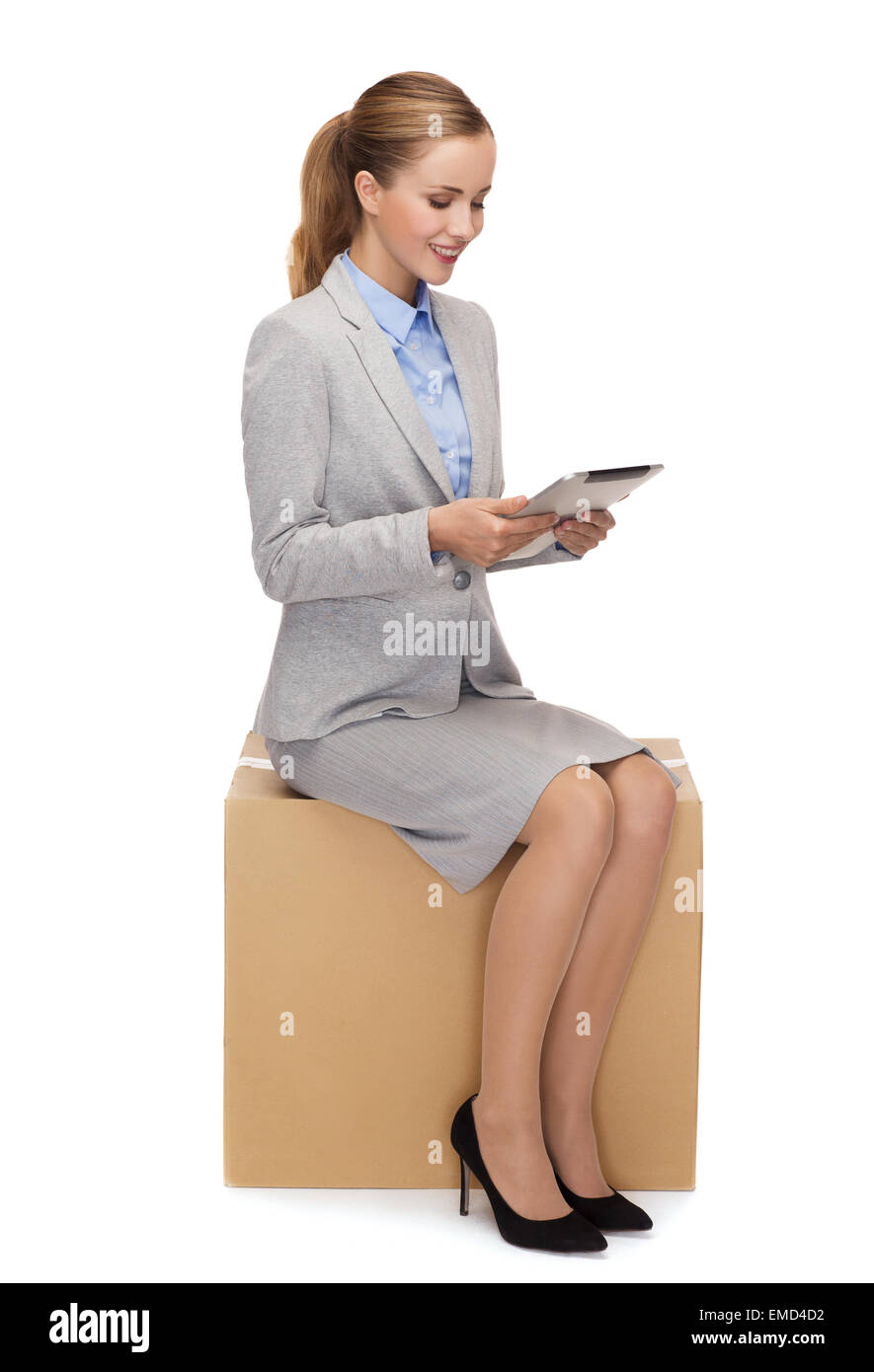 woman sitting on cardboard box with tablet pc Stock Photo - Alamy