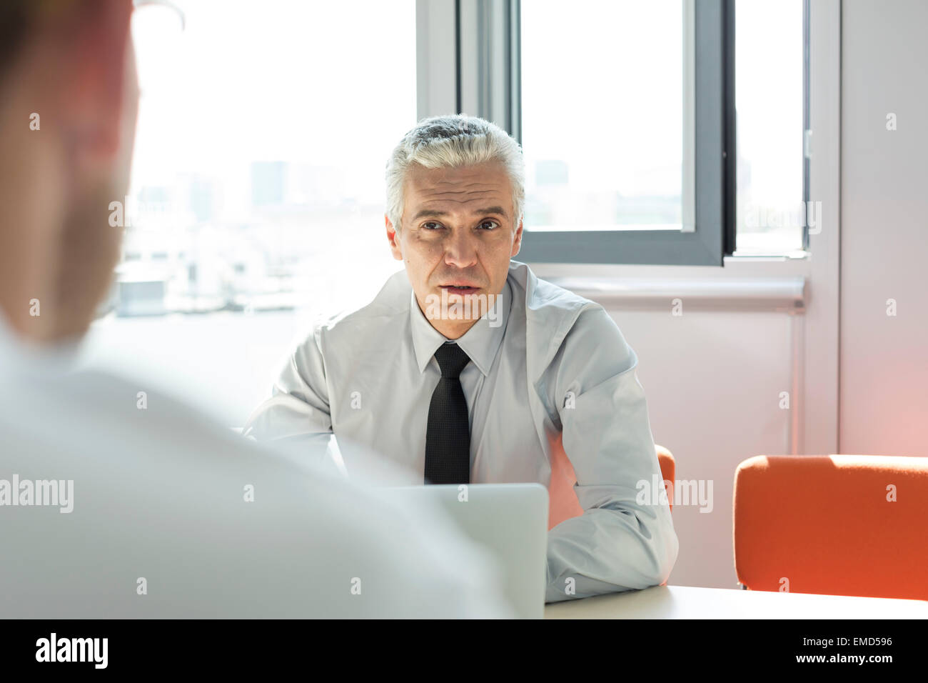 Mature manager listening to colleague Stock Photo - Alamy