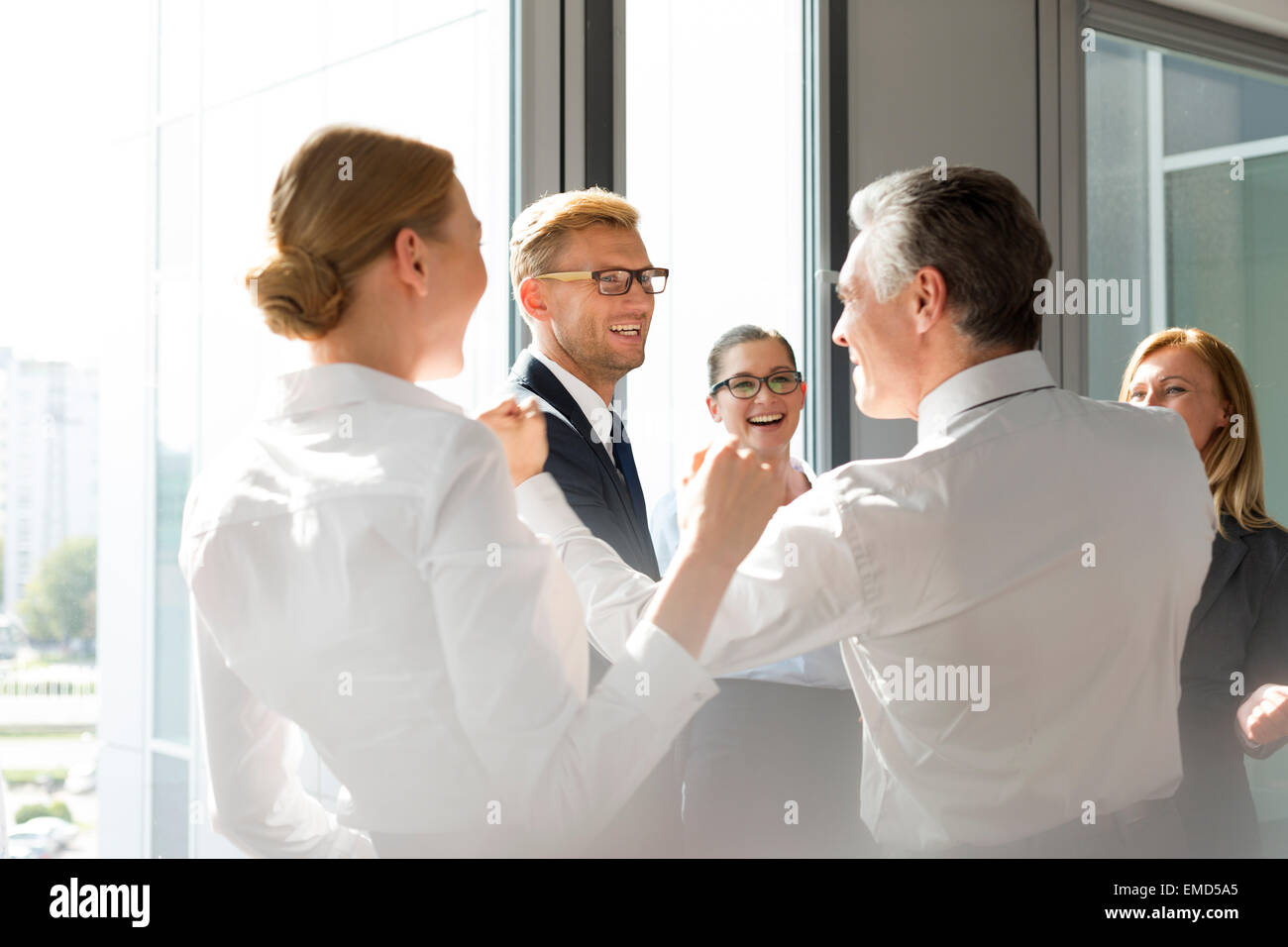 Laughing business people celebrating success Stock Photo - Alamy