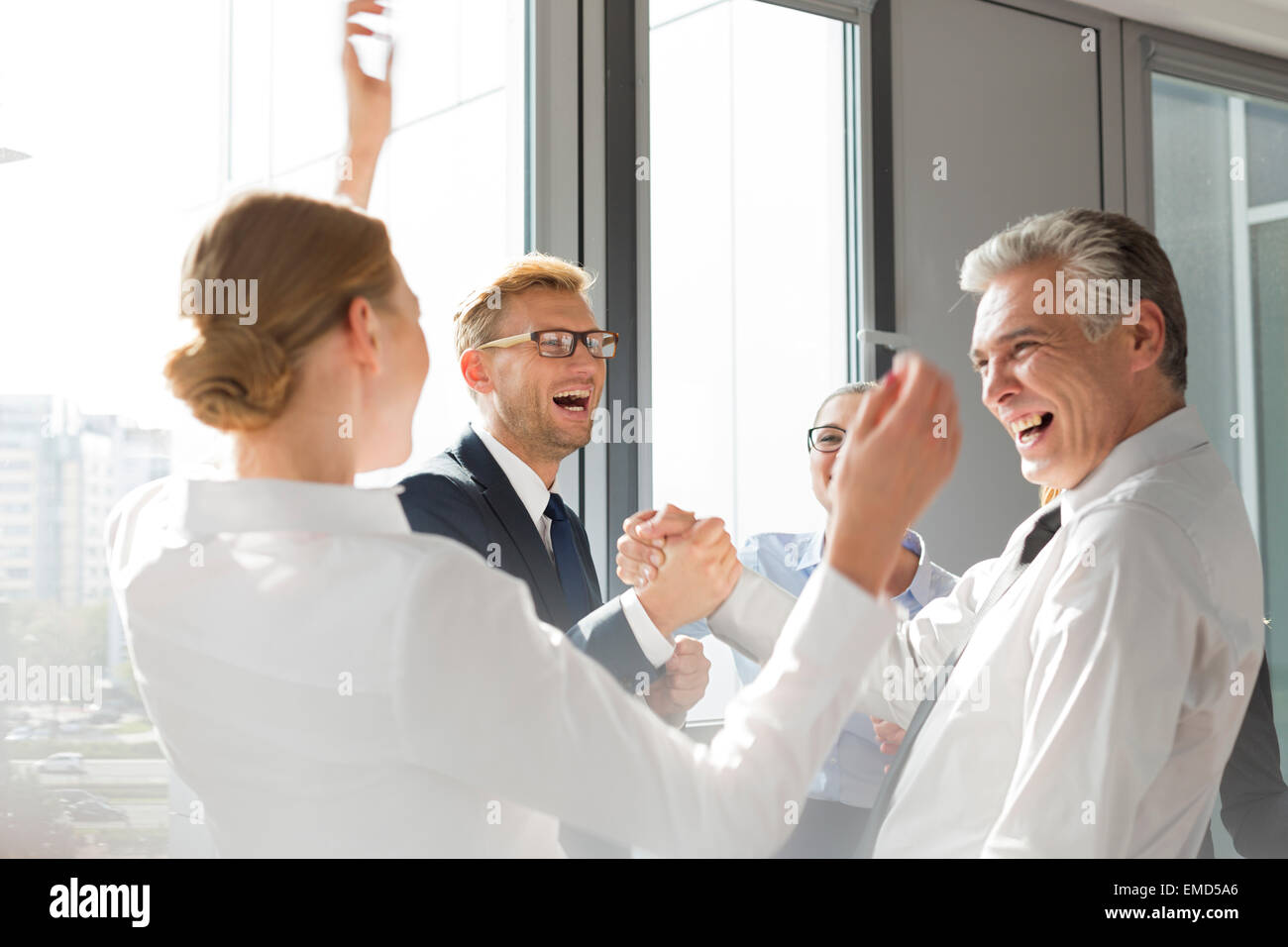 Laughing business people celebrating success Stock Photo - Alamy