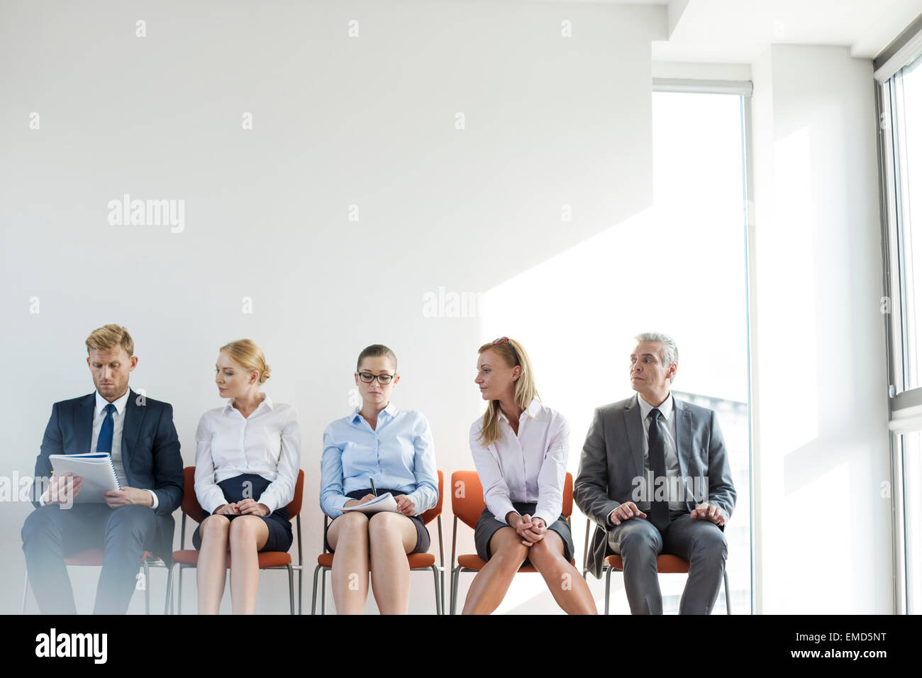 People sitting in a row, waiting for job interview Stock Photo - Alamy