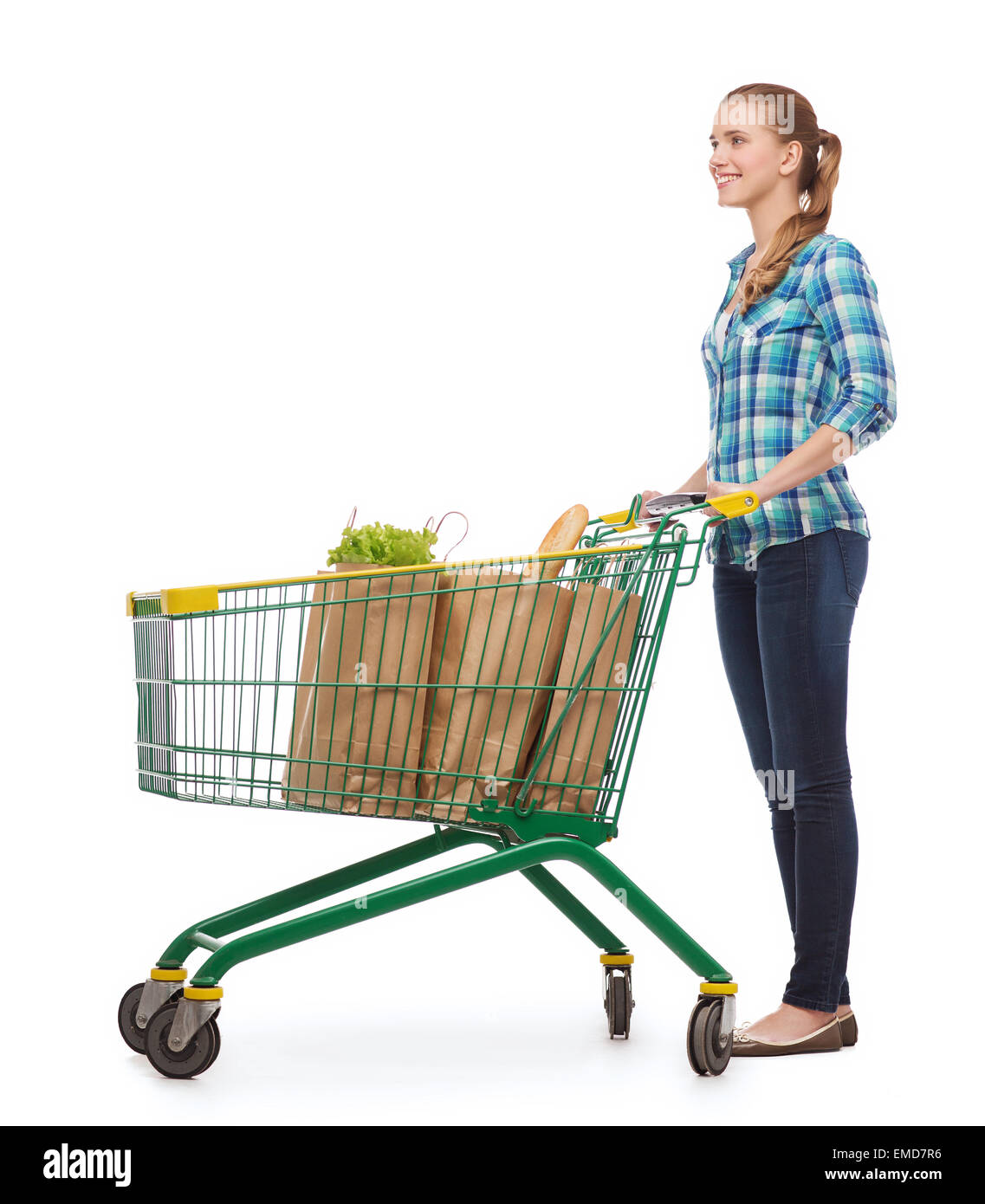 smiling young woman with shopping cart and food Stock Photo - Alamy