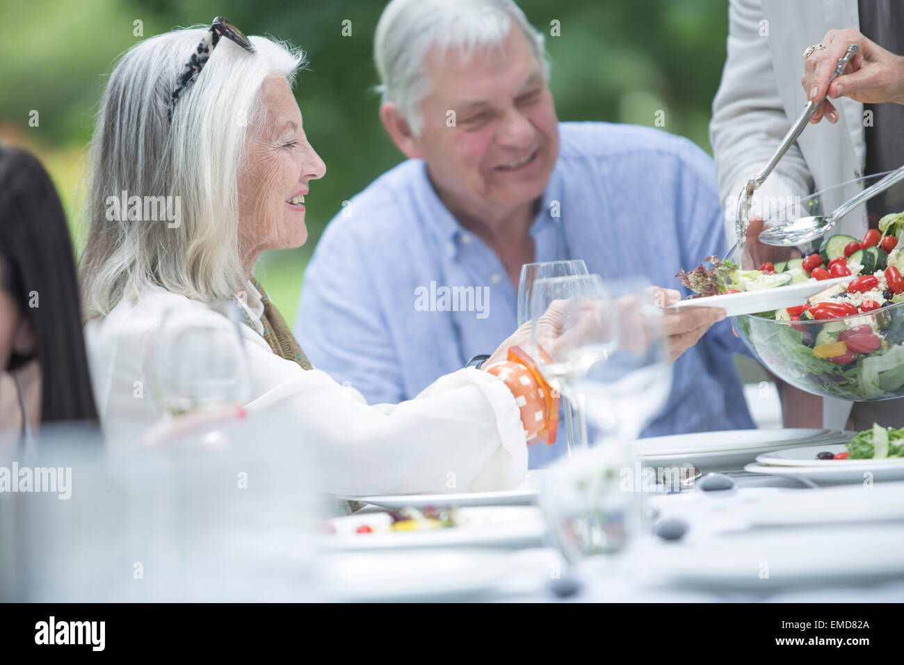 Woman dishing up salad on a garden party Stock Photo - Alamy