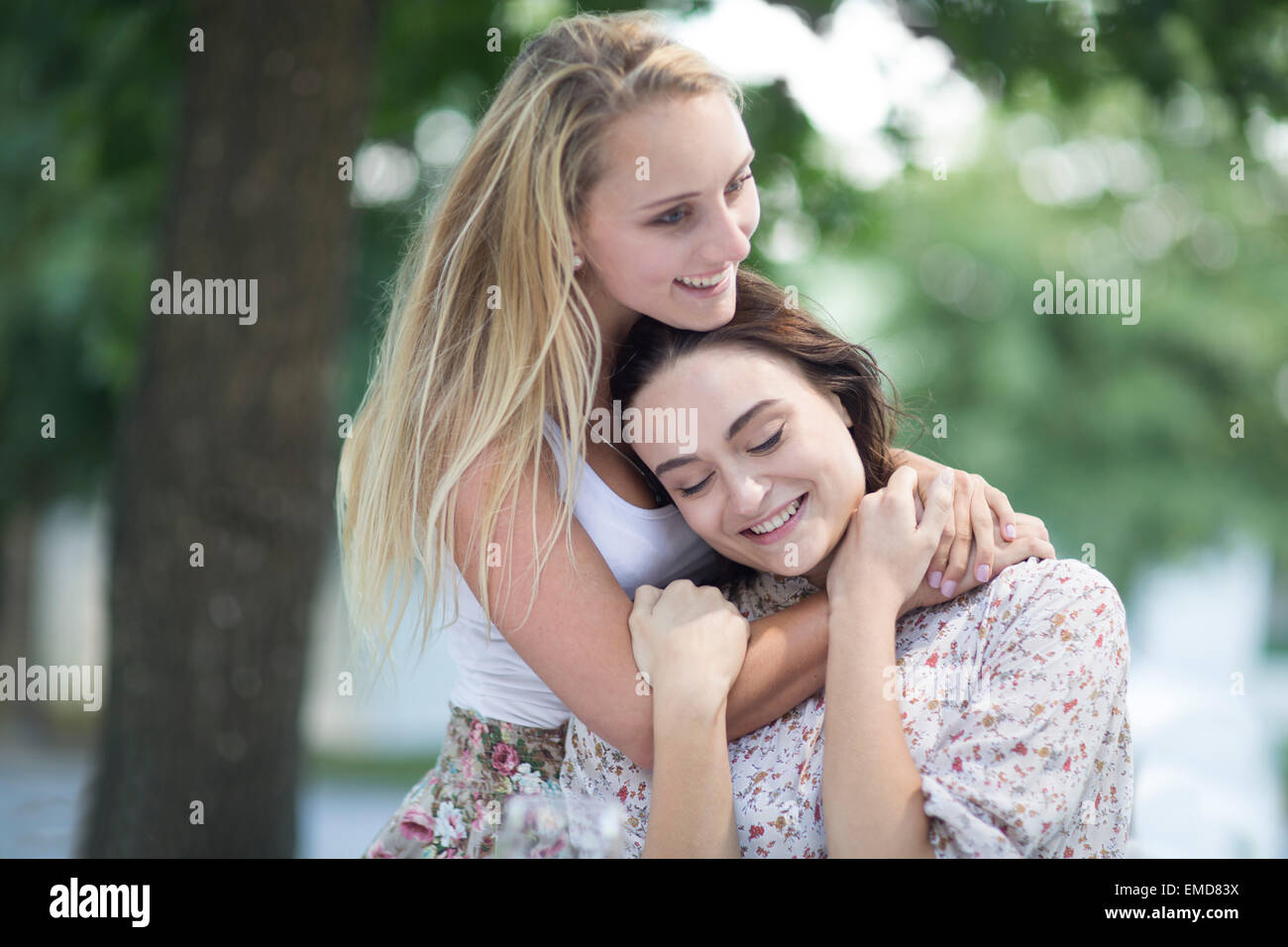 Friends hugging each other outdoors Stock Photo - Alamy