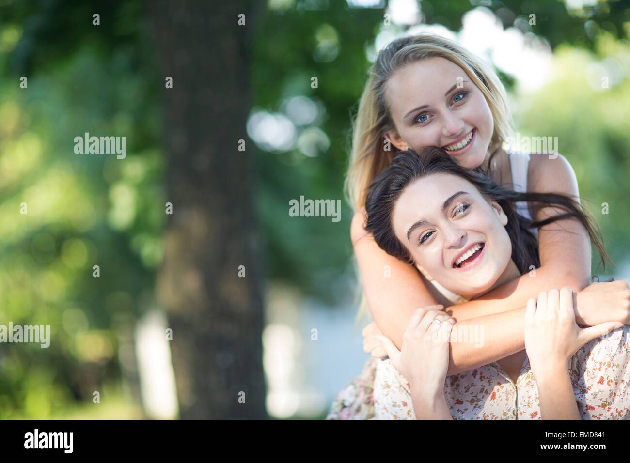 Friends hugging each other outdoors Stock Photo - Alamy