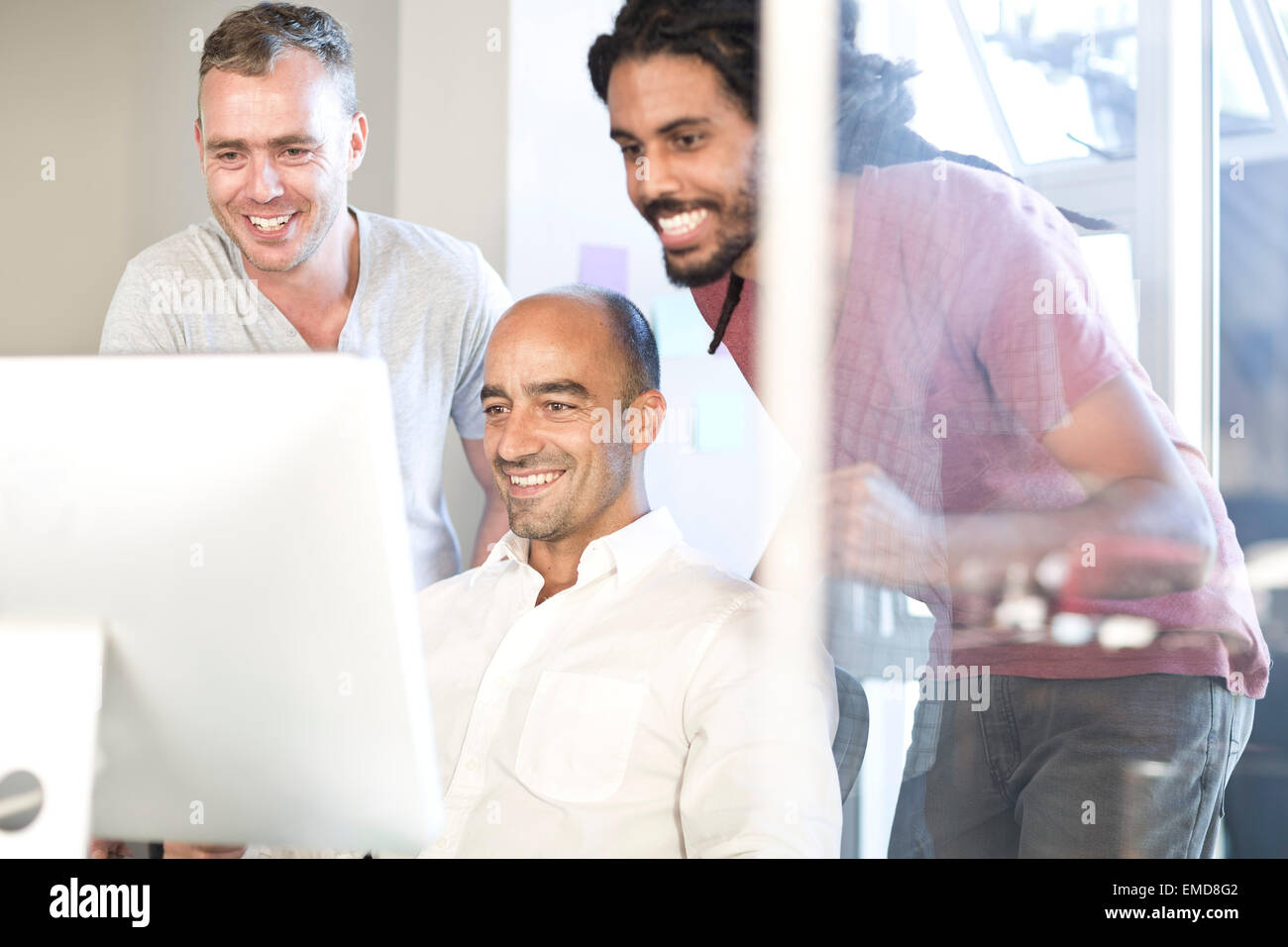 Three colleagues looking at screen in an office Stock Photo - Alamy
