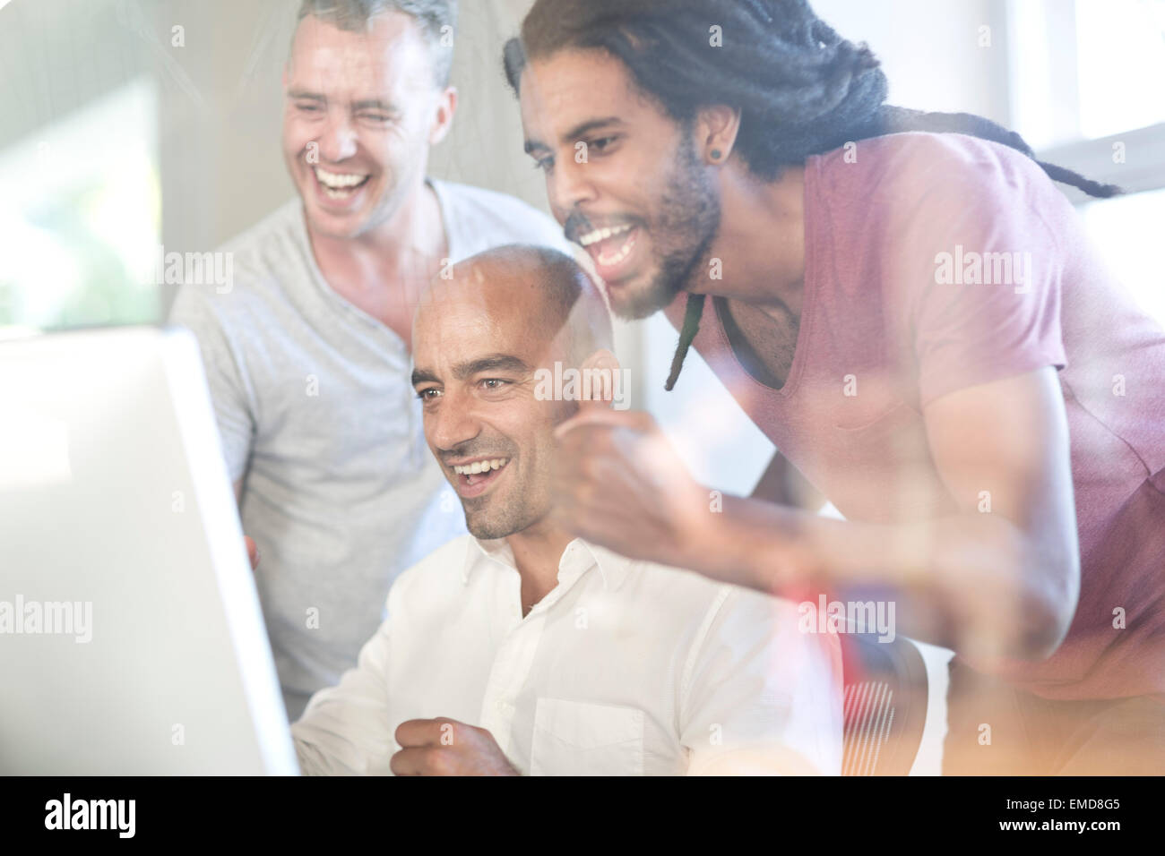 Three colleagues looking at screen in an office Stock Photo - Alamy