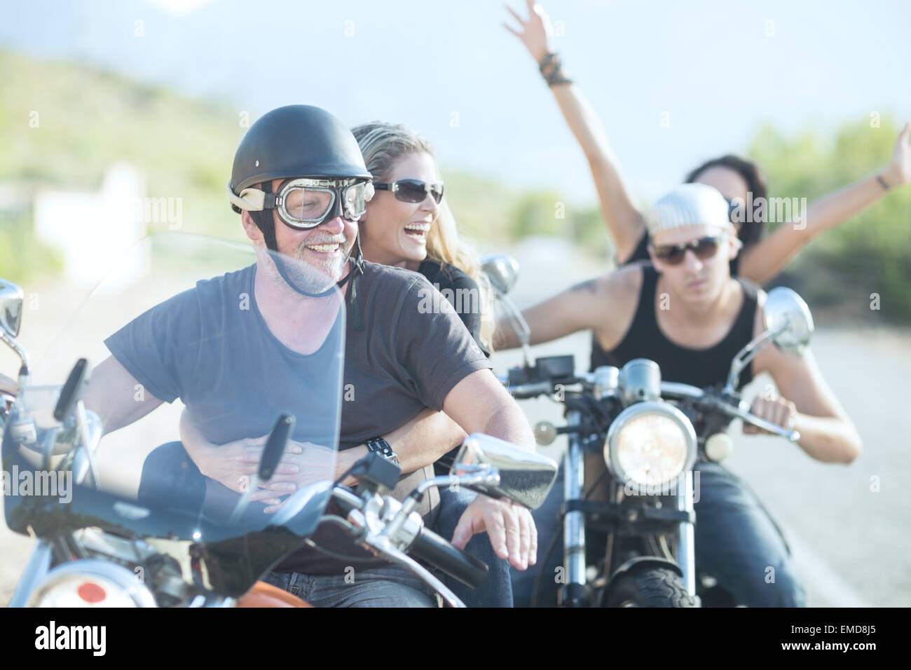 Two enthusiastic couples riding on motorcycles Stock Photo - Alamy