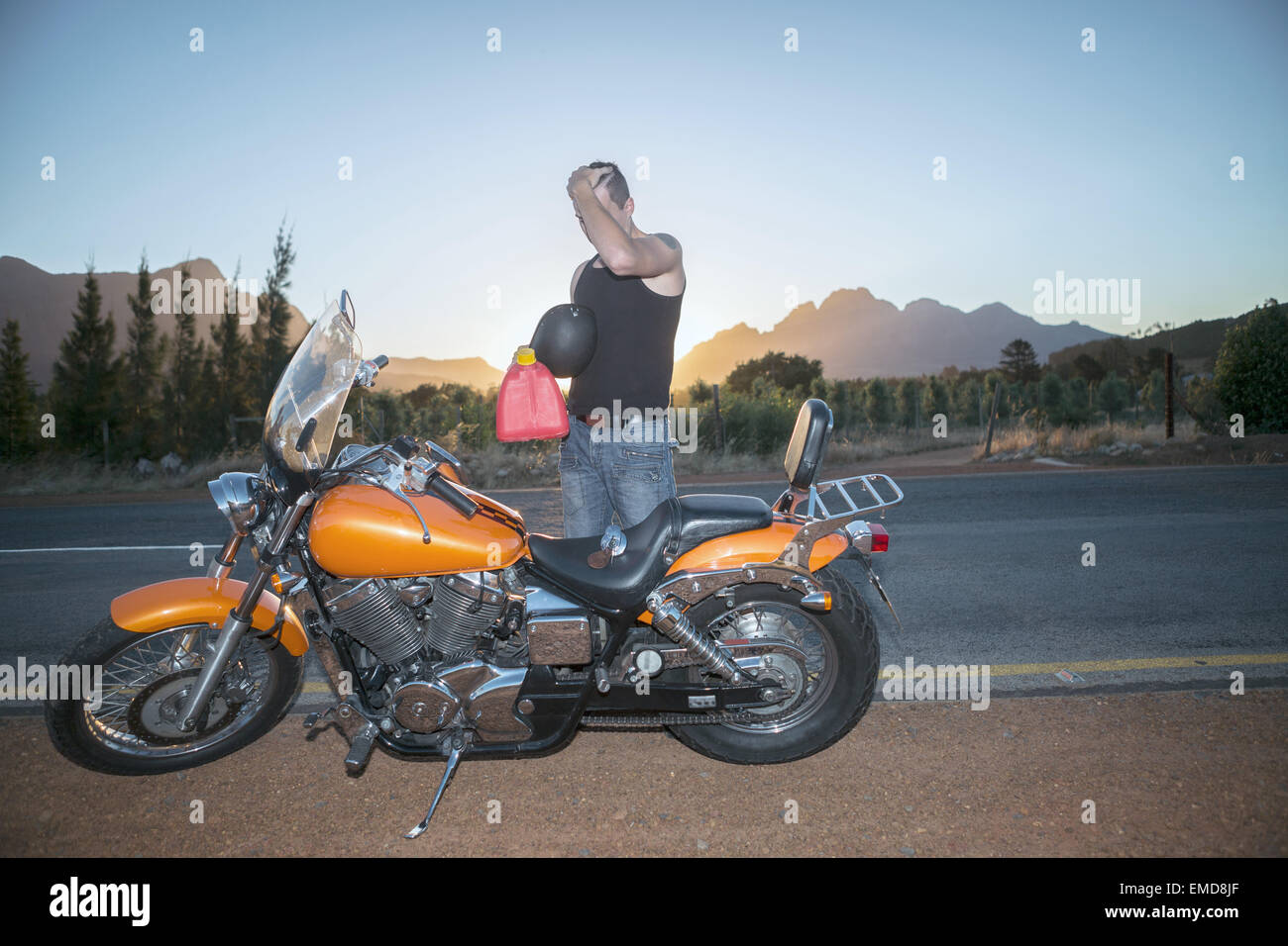 Biker with petrol can next to motorcycle by the roadside Stock Photo ...