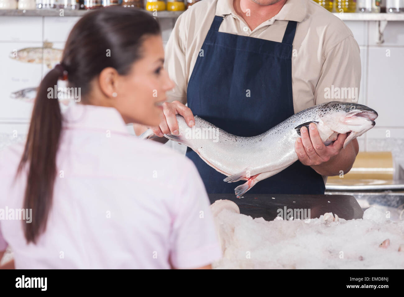Woman buying fish Stock Photo - Alamy