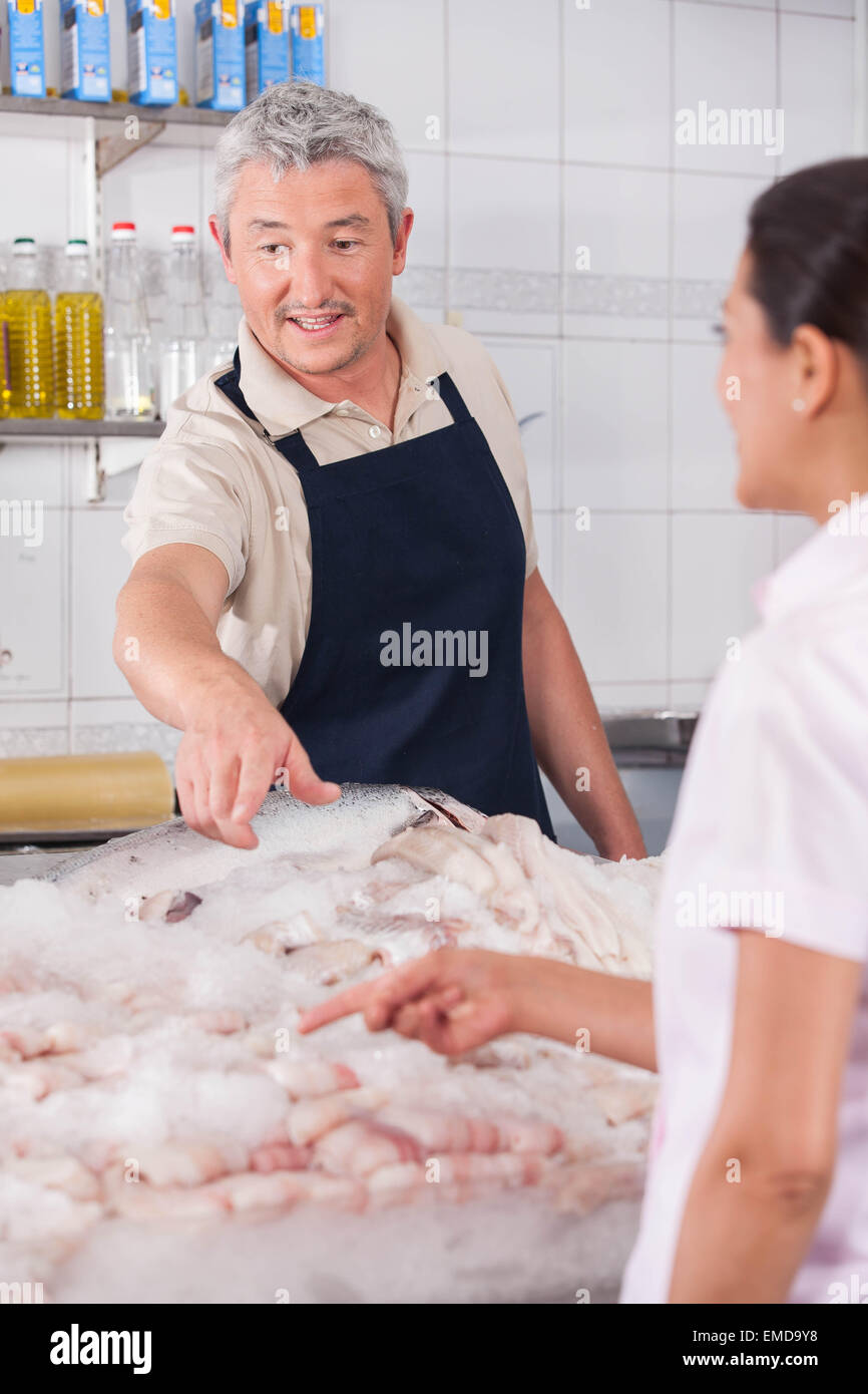 Woman buying fish Stock Photo - Alamy