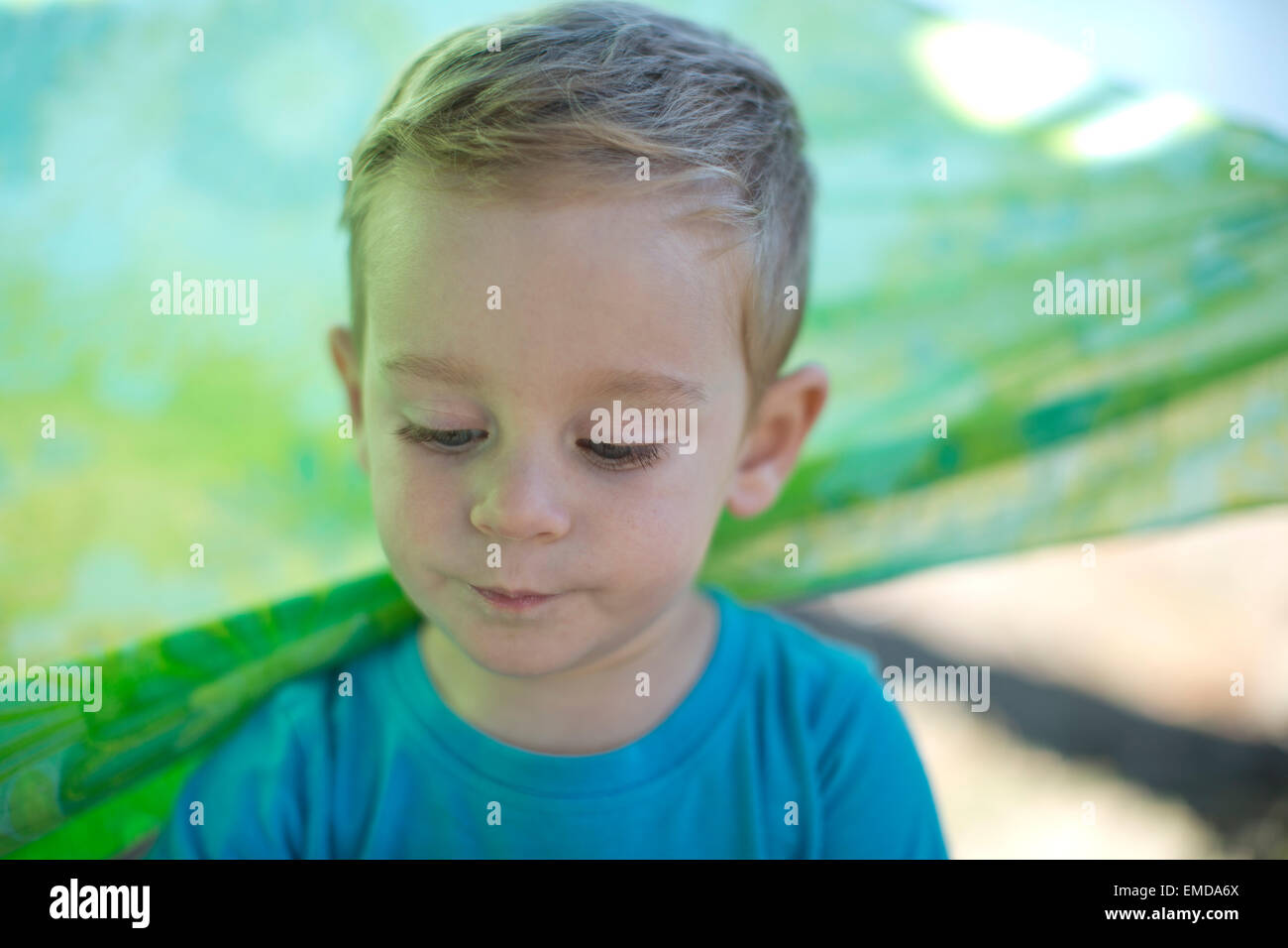 Portrait of little boy outdoors looking down Stock Photo - Alamy