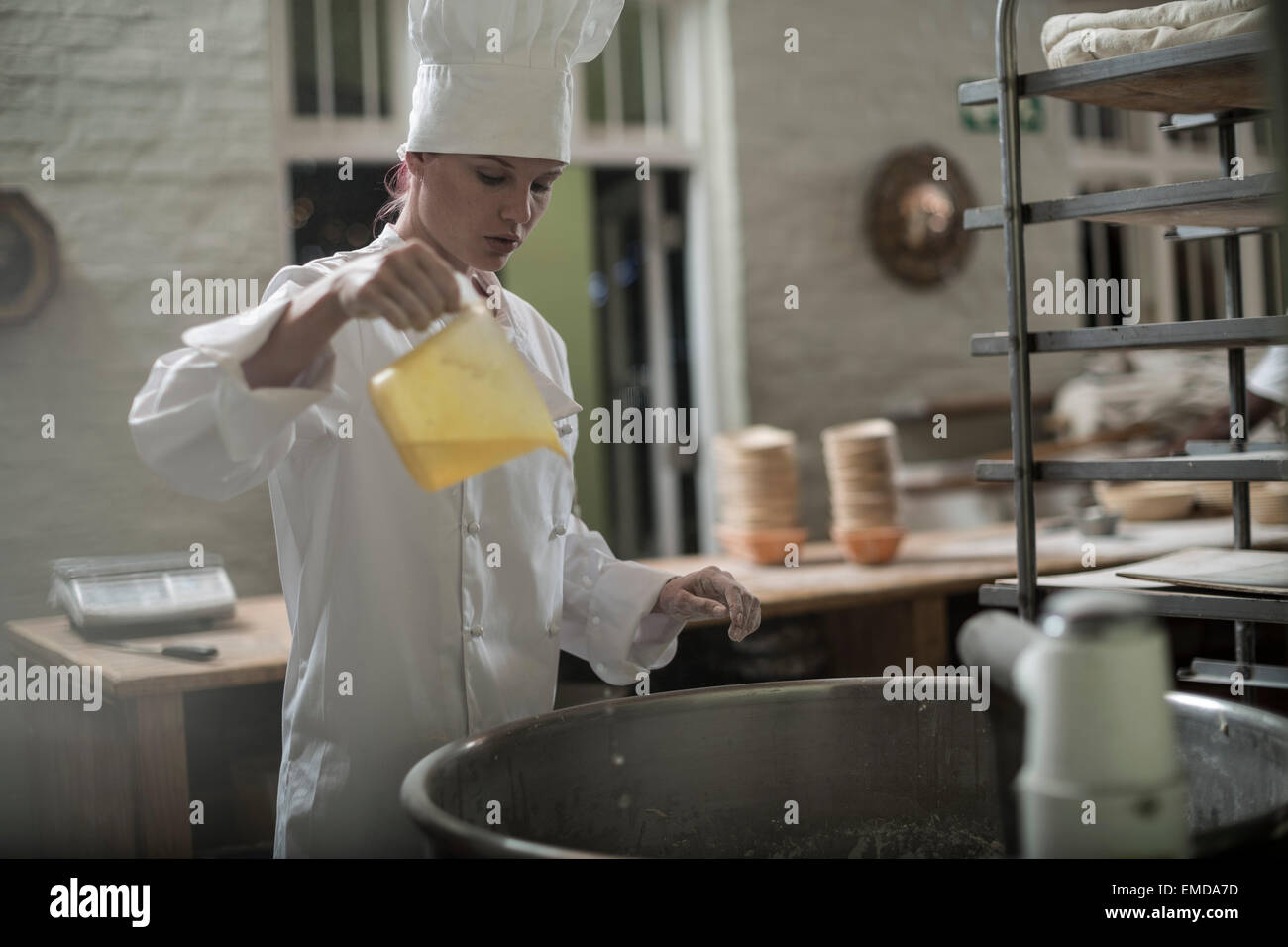 Female baker pouring ingredient into mixer Stock Photo - Alamy