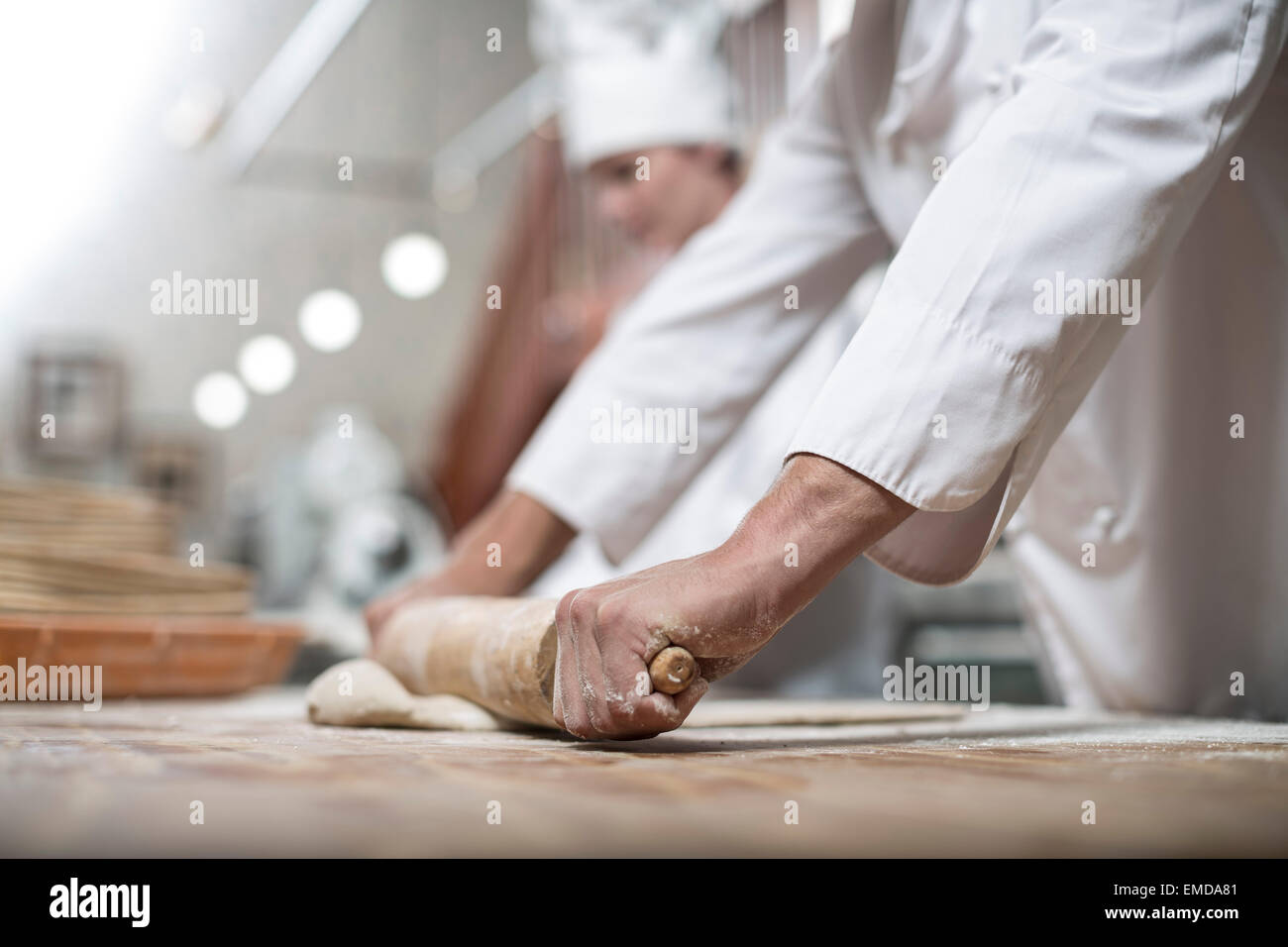 Baker rolling out dough Stock Photo - Alamy