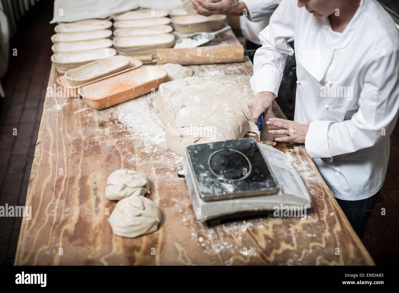 Female baker cutting dough Stock Photo - Alamy