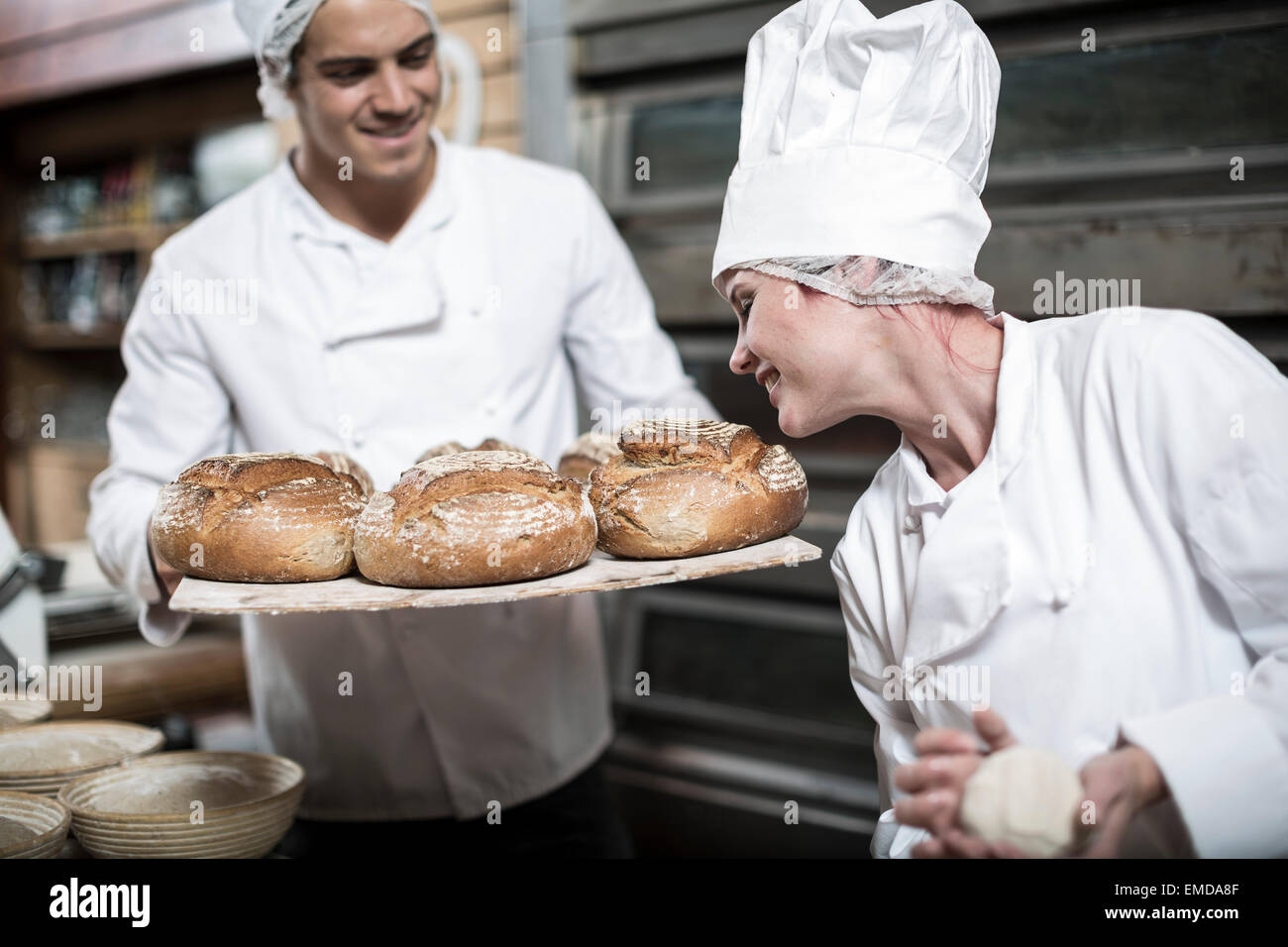 Female baker smelling fresh bread Stock Photo - Alamy
