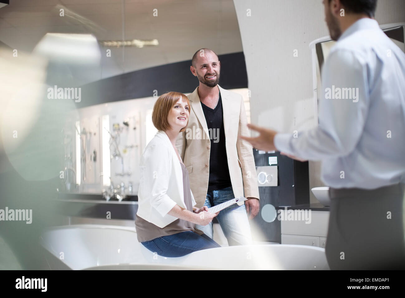 Bathroom shop salesman explaining customers some products Stock Photo ...