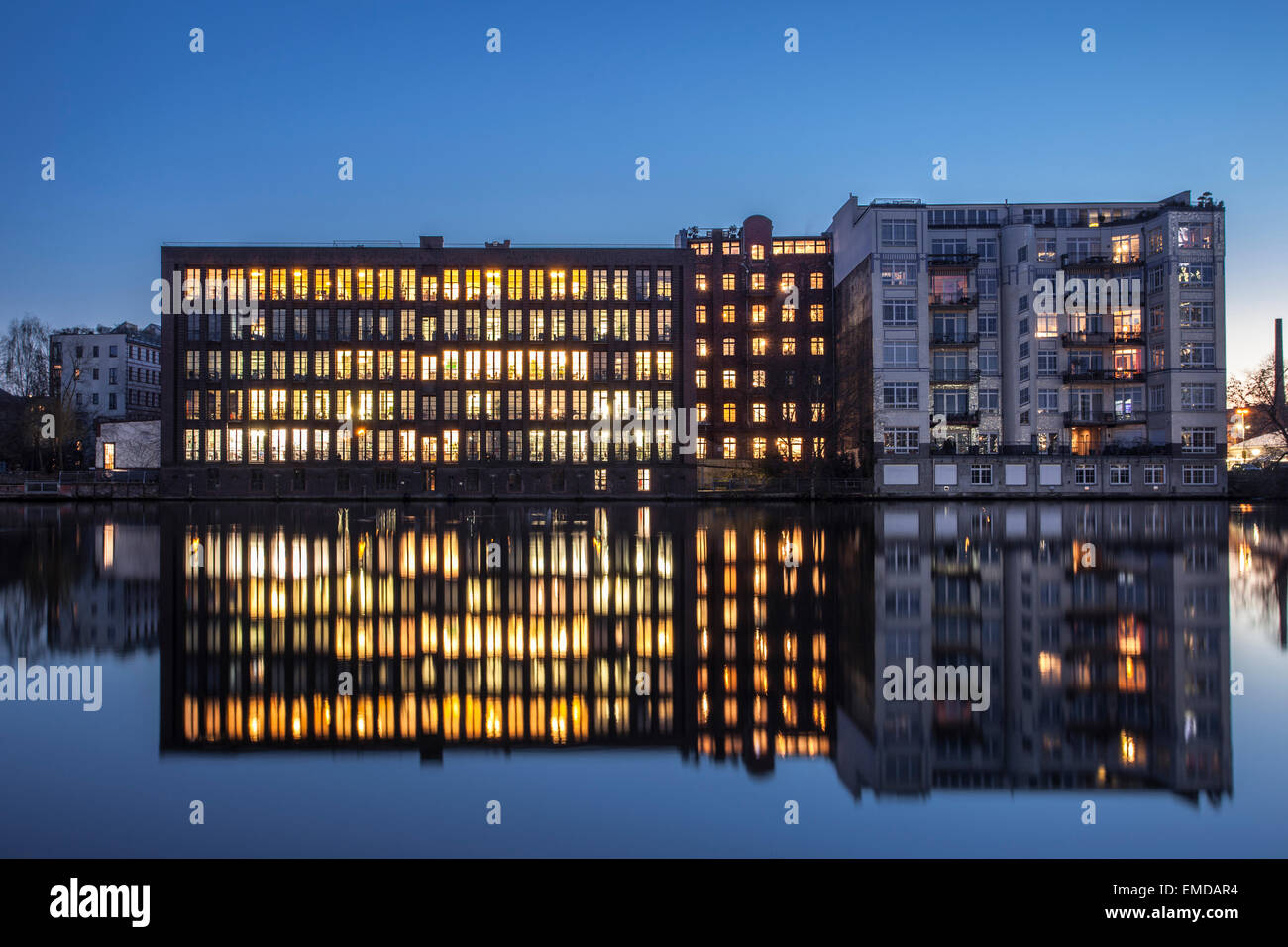 Germany, Berlin, lighted office building and water reflections in the ...