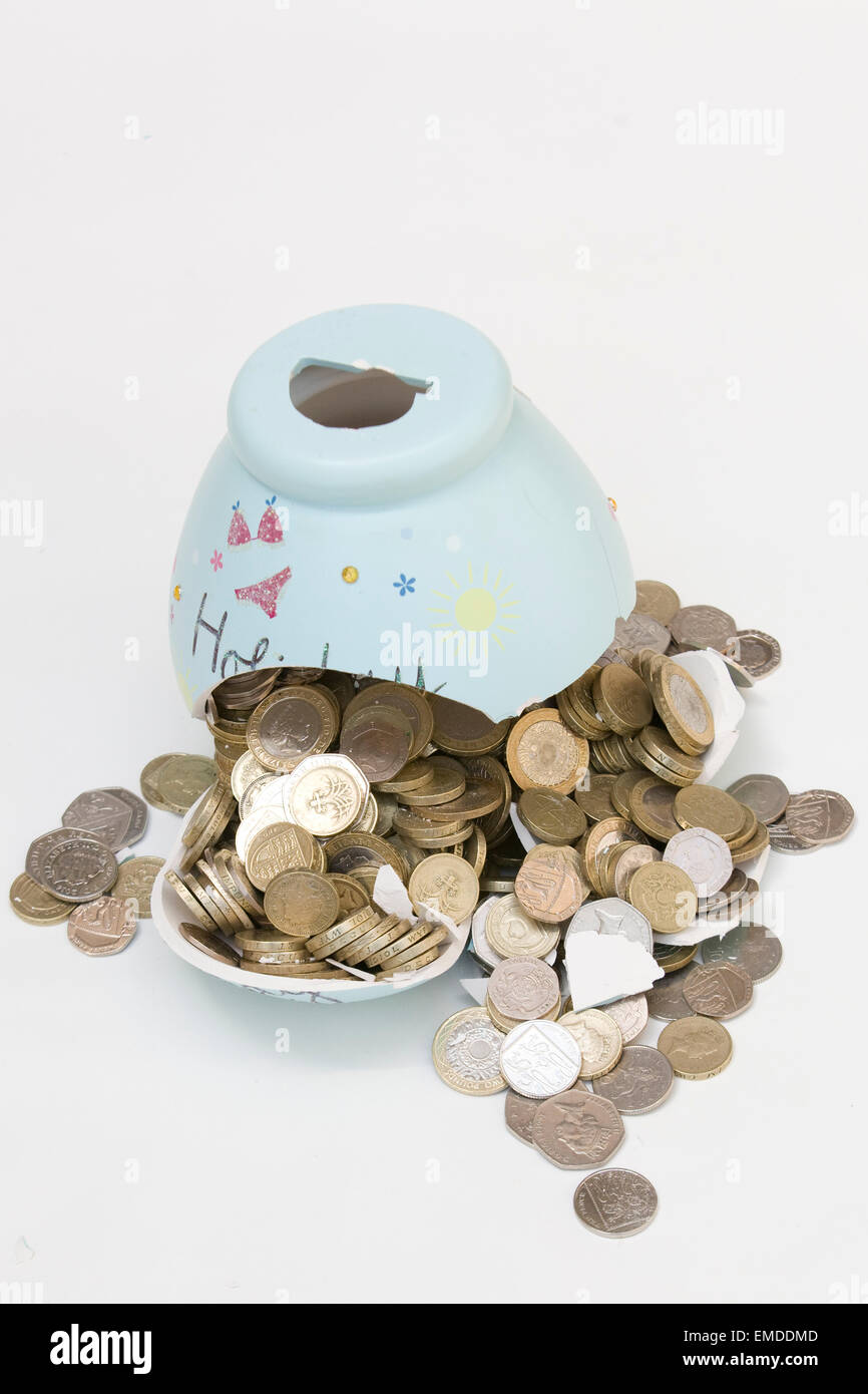 Smashed Money box with Coins pouring out of it on a white background ...