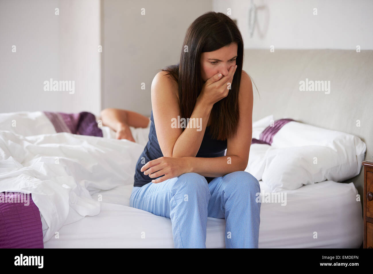Woman Sitting On Bed And Feeling Unwell Stock Photo - Alamy
