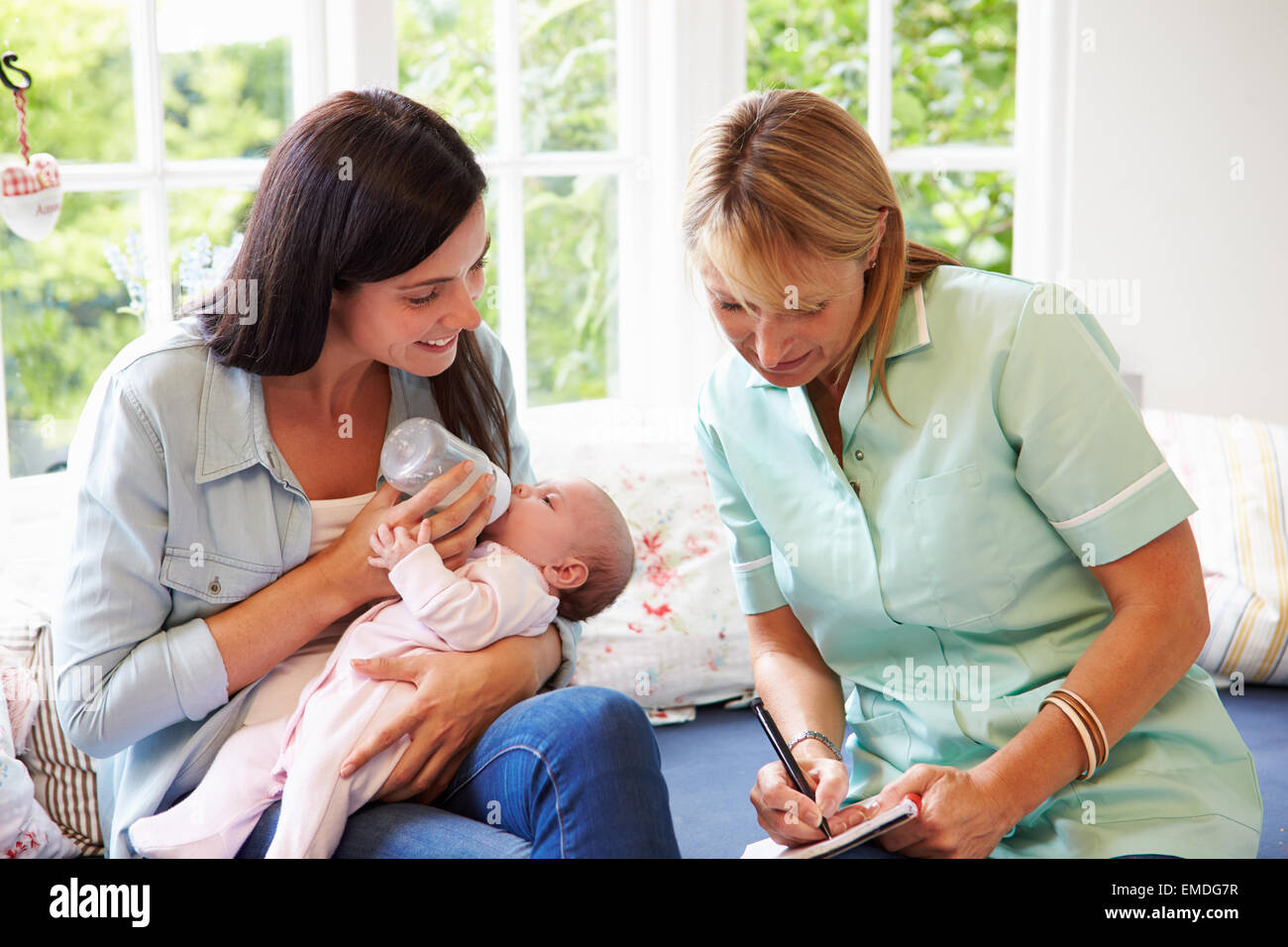 Mother With Baby Meeting With Health Visitor At Home Stock Photo - Alamy