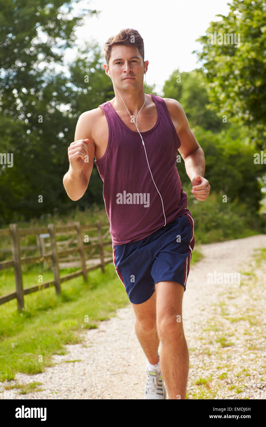 Man Running In Countryside Wearing Earphones Stock Photo - Alamy
