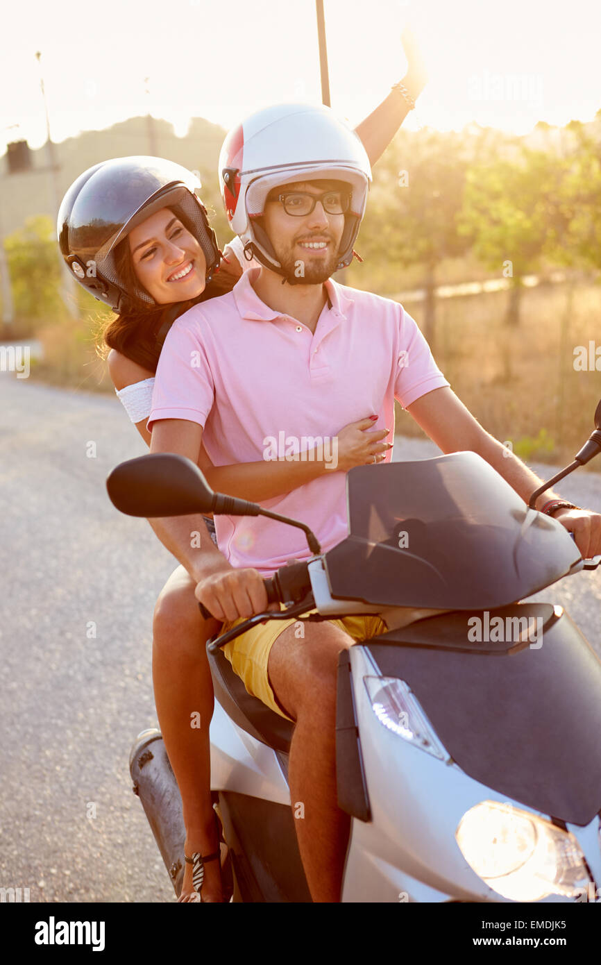 Young Couple Riding Motor Scooter Along Country Road Stock Photo - Alamy
