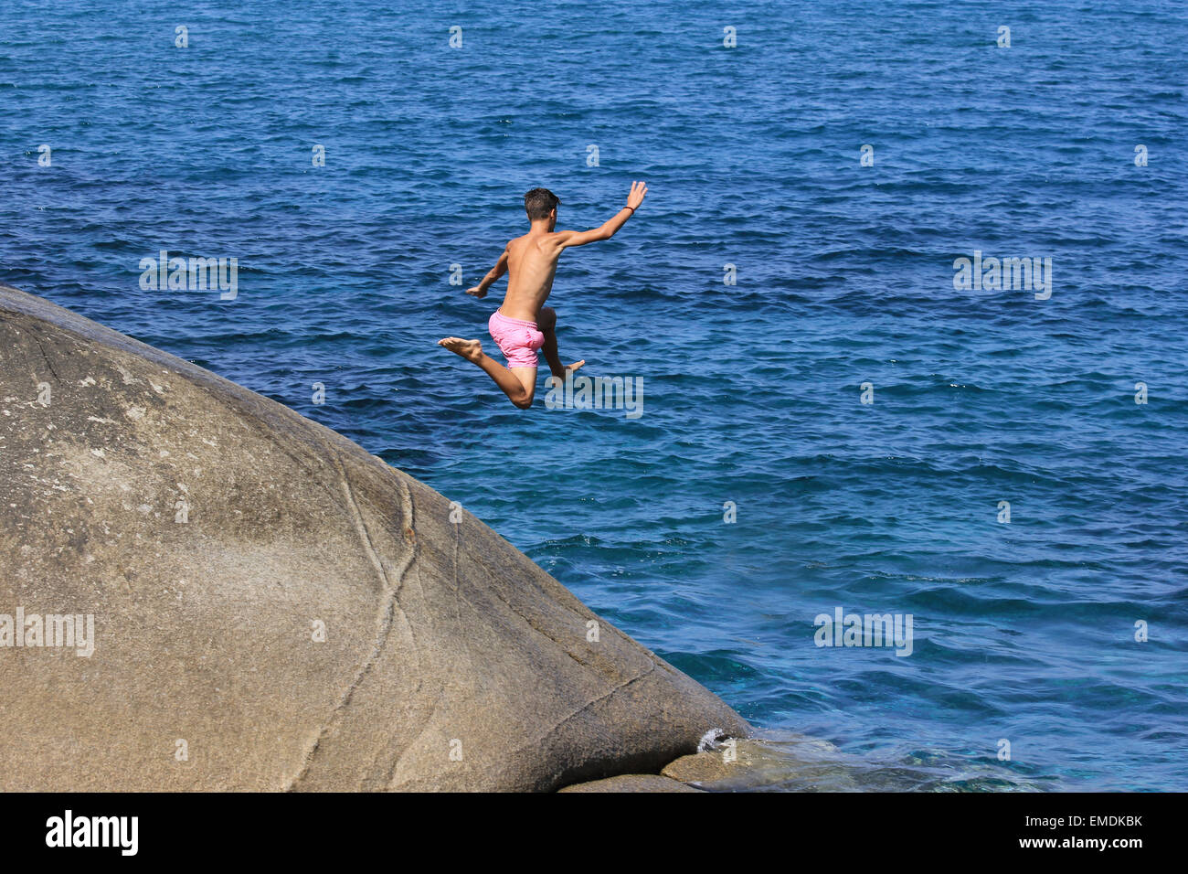 a boy diving off the rocks into the Aegean sea in a Greek island Stock ...
