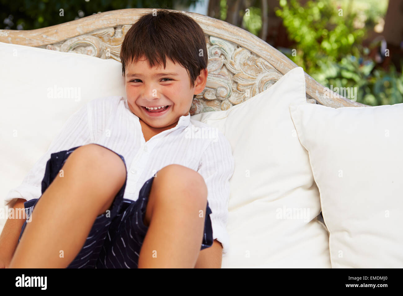 Smiling Hispanic Boy At Home Sitting On Outdoor Seat Stock Photo - Alamy