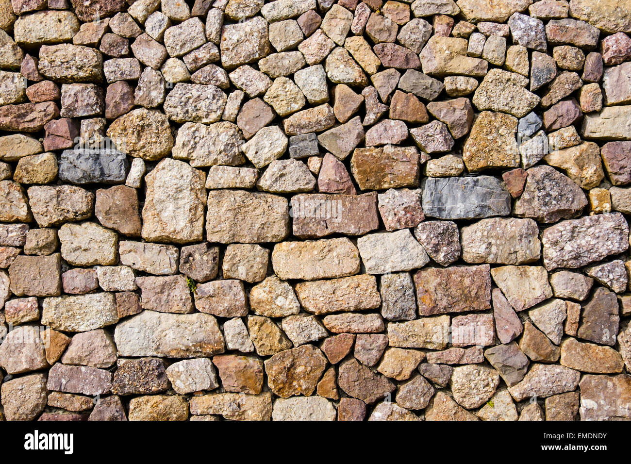 Stones of different shapes, sizes and colours in a dry stone wall on a ...