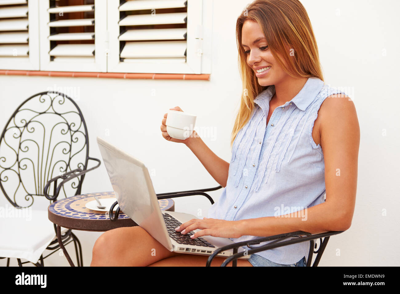 Young Woman Sitting Outdoors With Laptop And Drinking Coffee Stock ...