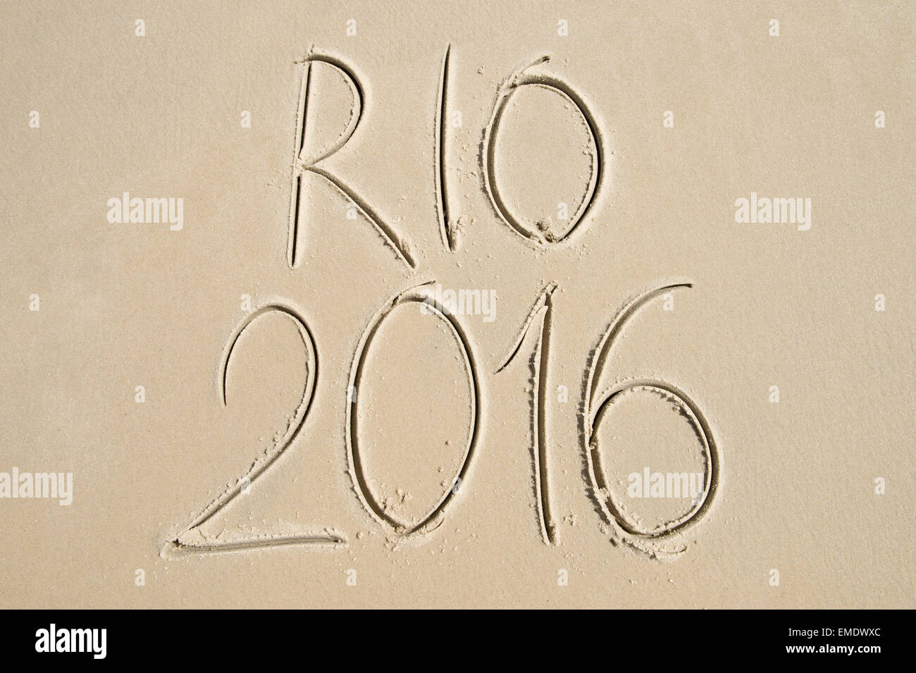 Simple Rio 2016 message handwritten in clean numbers on smooth sand ...