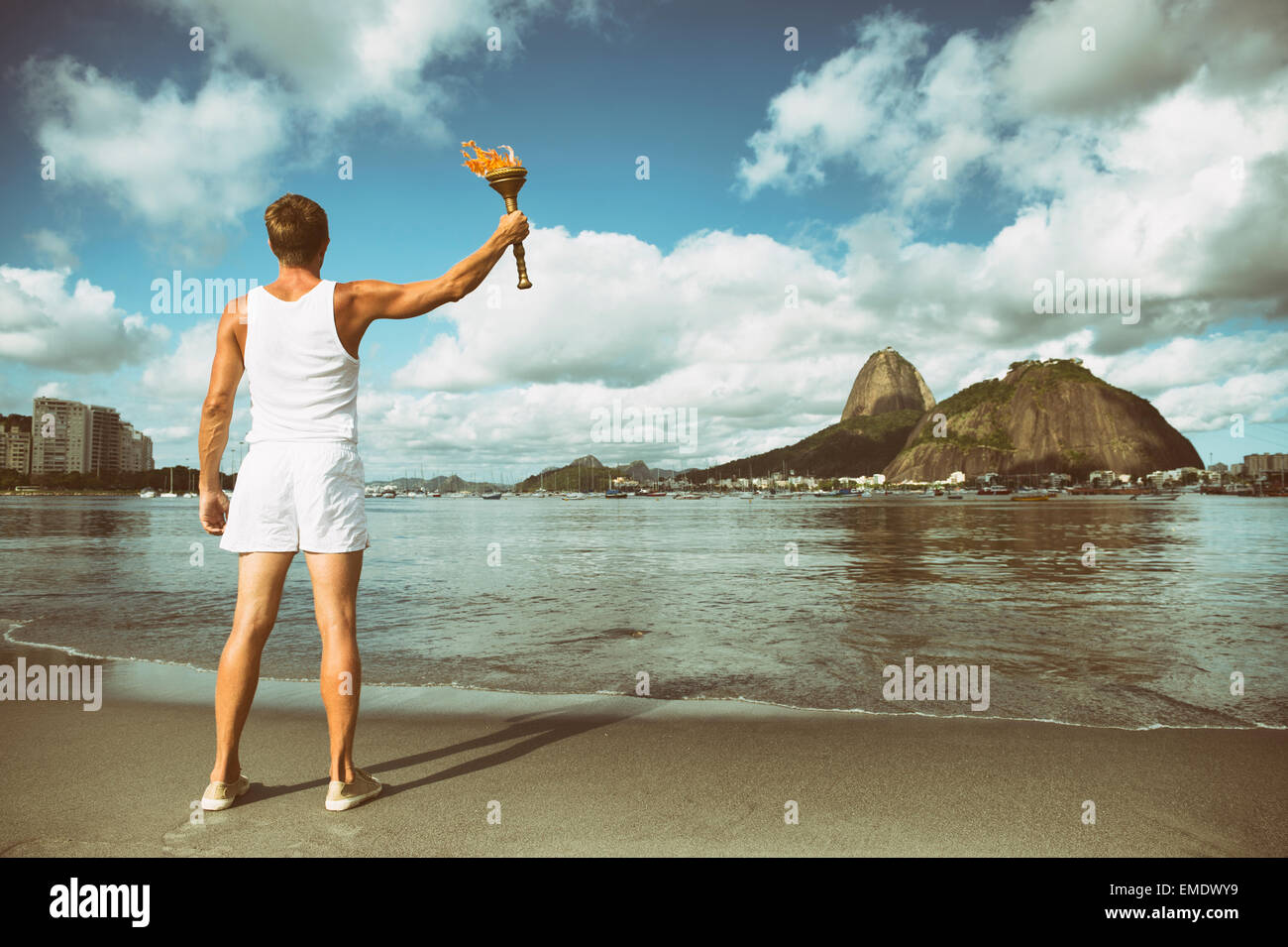 Young athletic man standing with sport torch against Rio de Janeiro ...