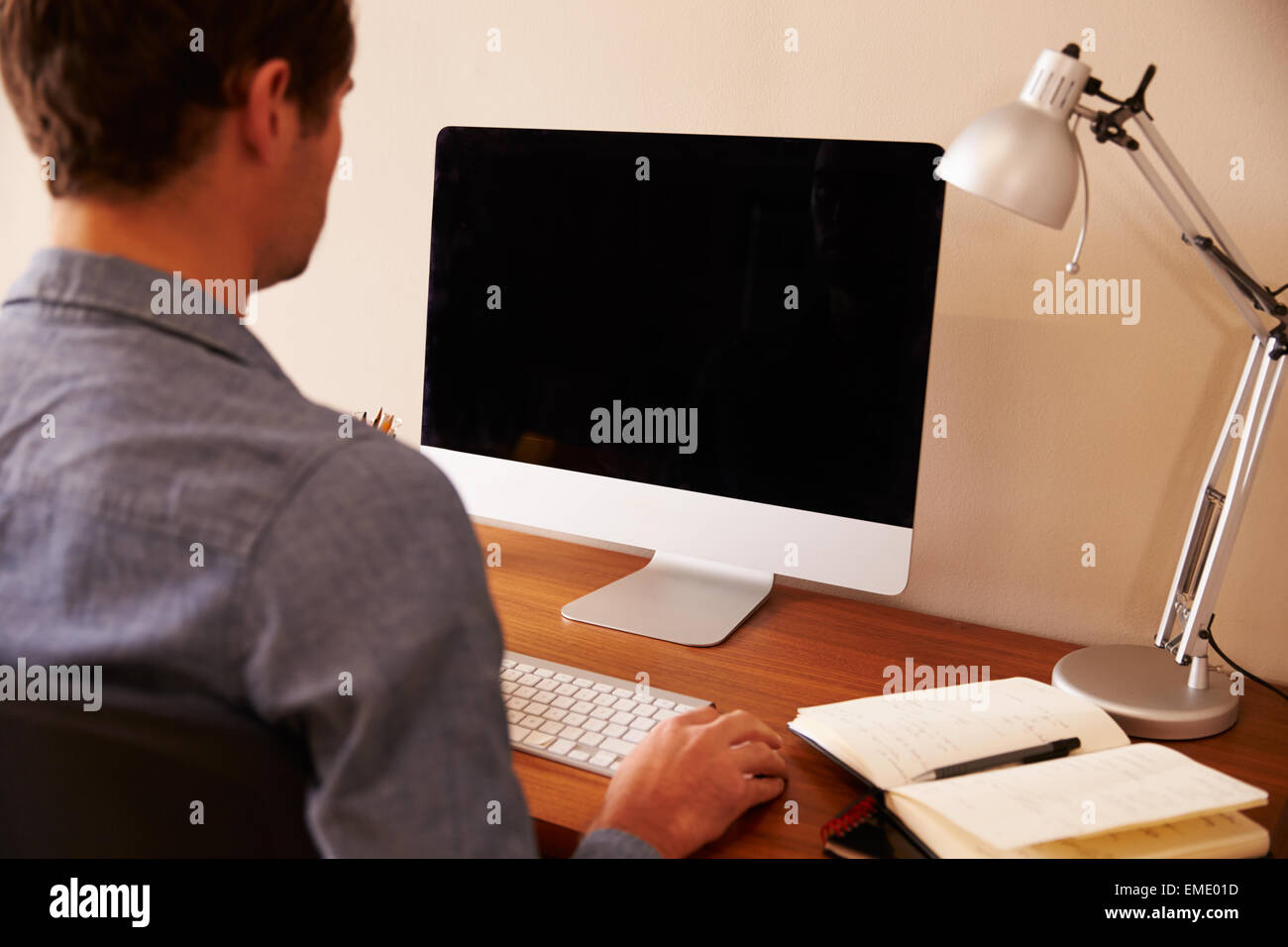 Man Sitting At Desk Working At Computer In Home Office Stock Photo - Alamy