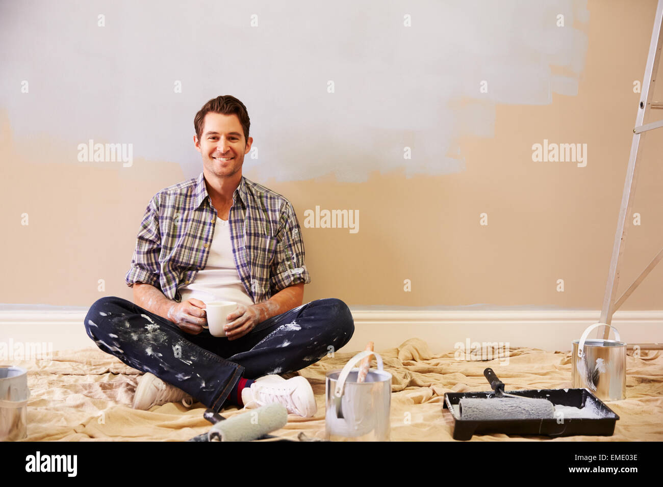 Man Taking A Break Whilst Decorating Room Stock Photo - Alamy