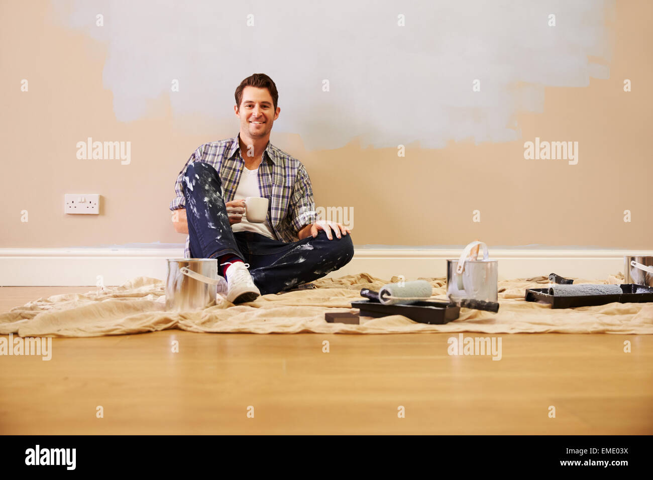 Man Taking A Break Whilst Decorating Room Stock Photo - Alamy
