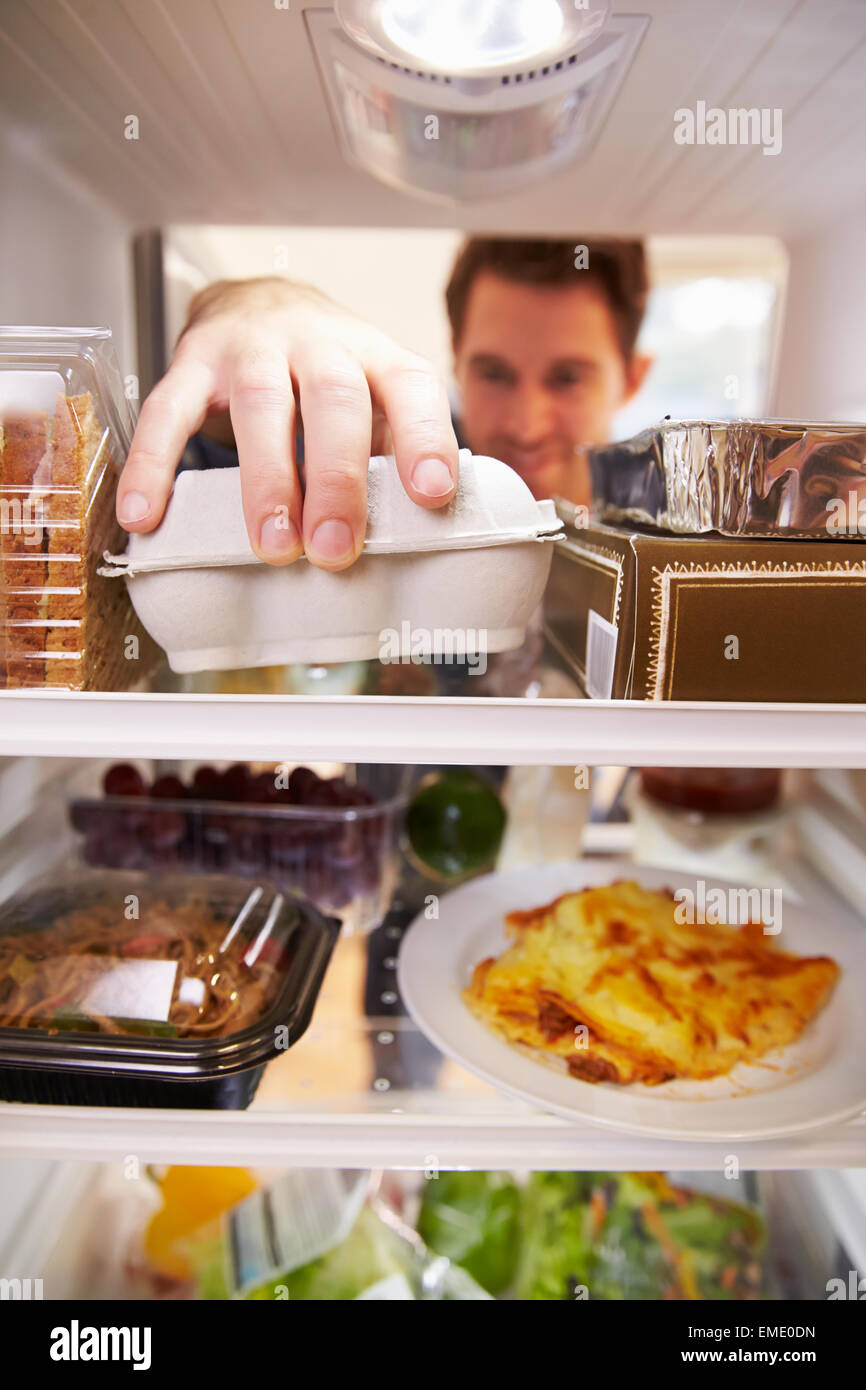 Man Looking Inside Fridge Filled With Food And Choosing Eggs Stock ...