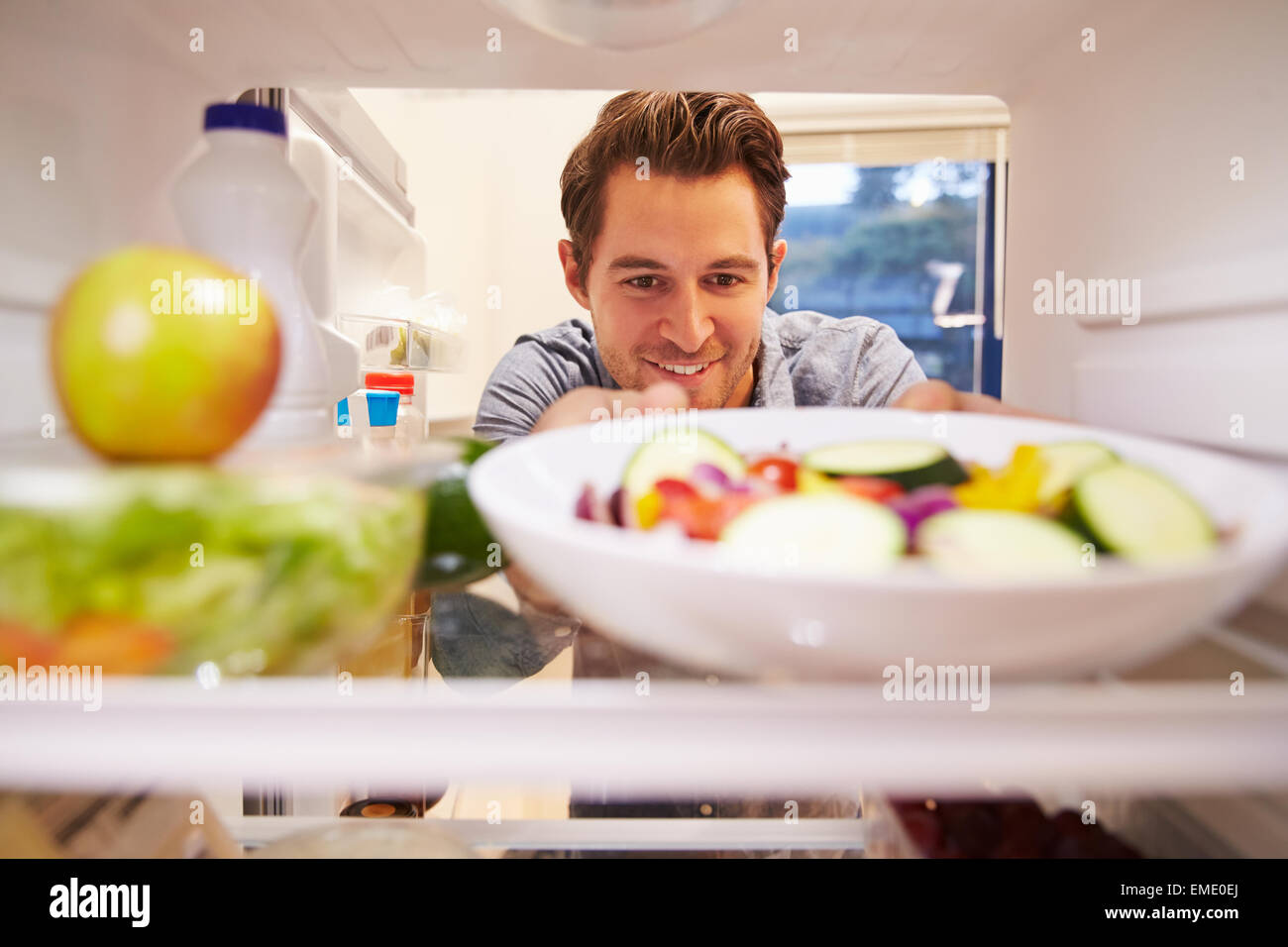 Man Looking Inside Fridge Full Of Food And Choosing Salad Stock Photo ...