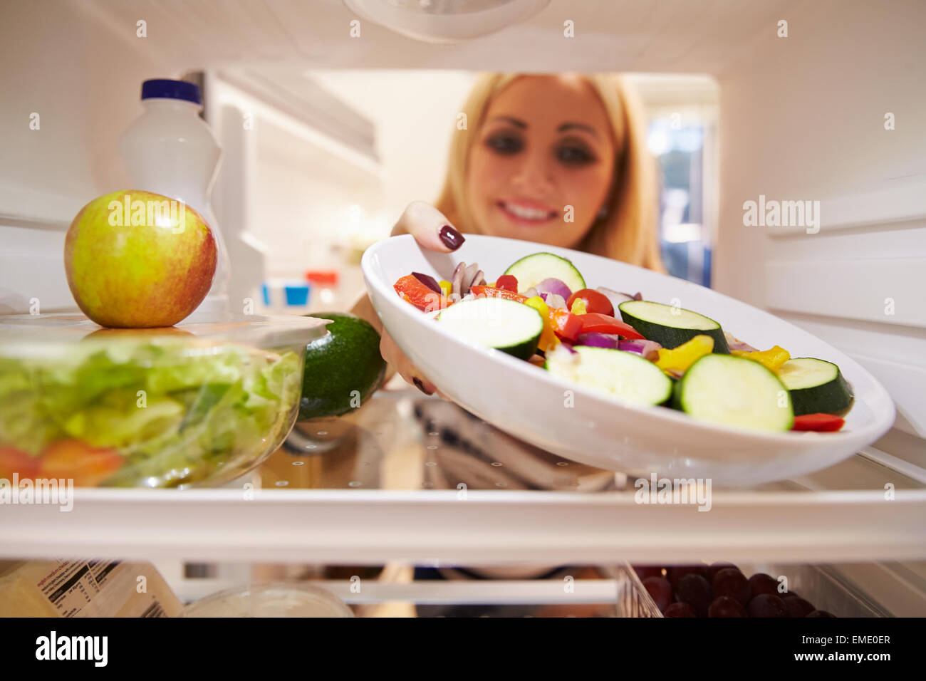 Woman Looking Inside Fridge Full Of Food And Choosing Salad Stock Photo ...