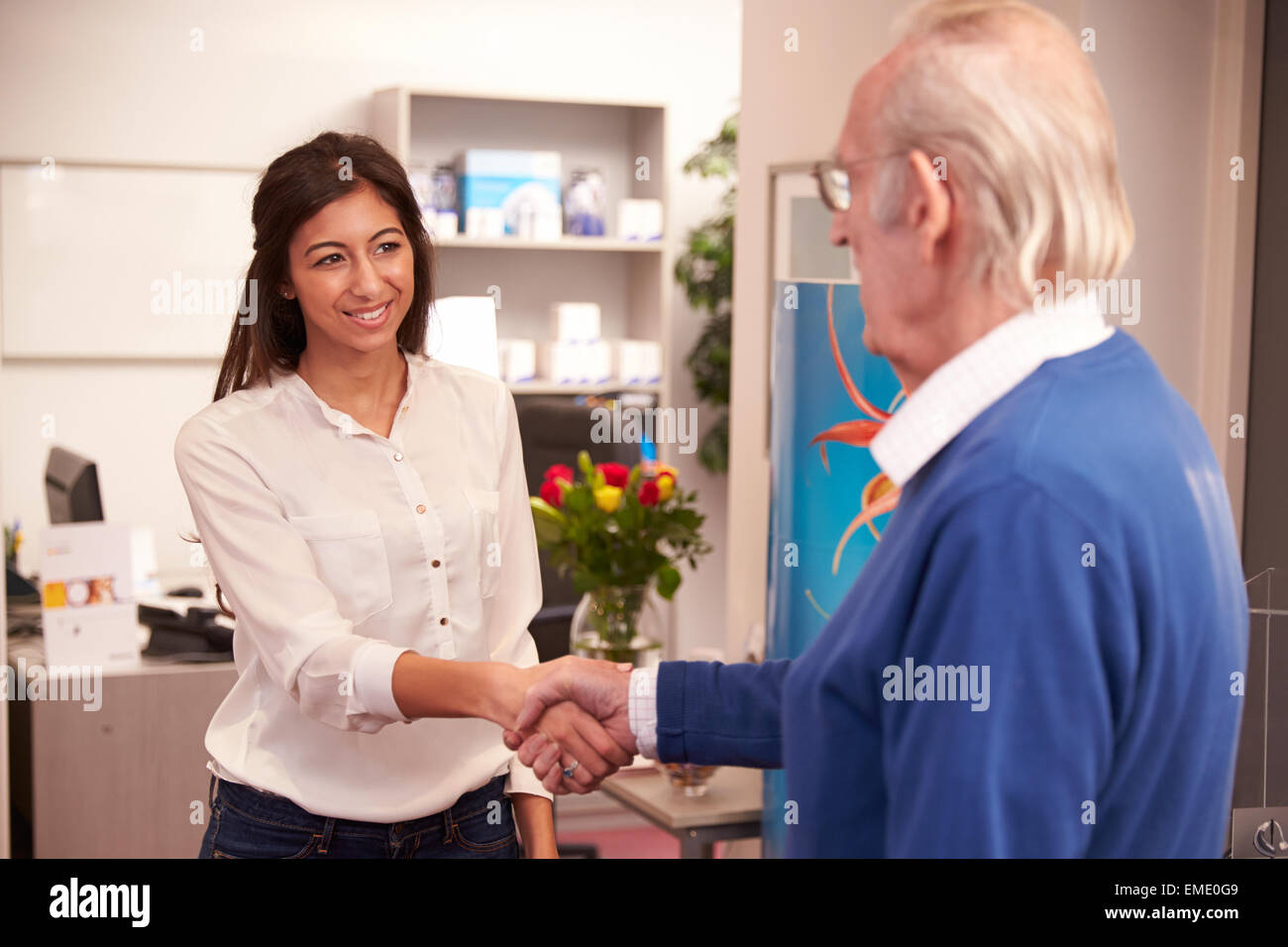 Receptionist Greeting Senior Male Patient At Hearing Clinic Stock Photo ...