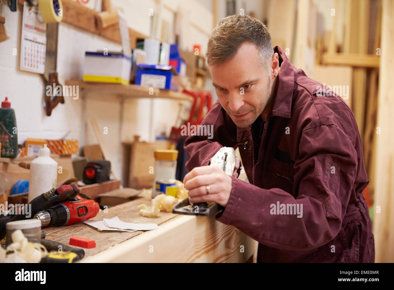 Carpenter Planing Wood In Workshop Stock Photo - Alamy