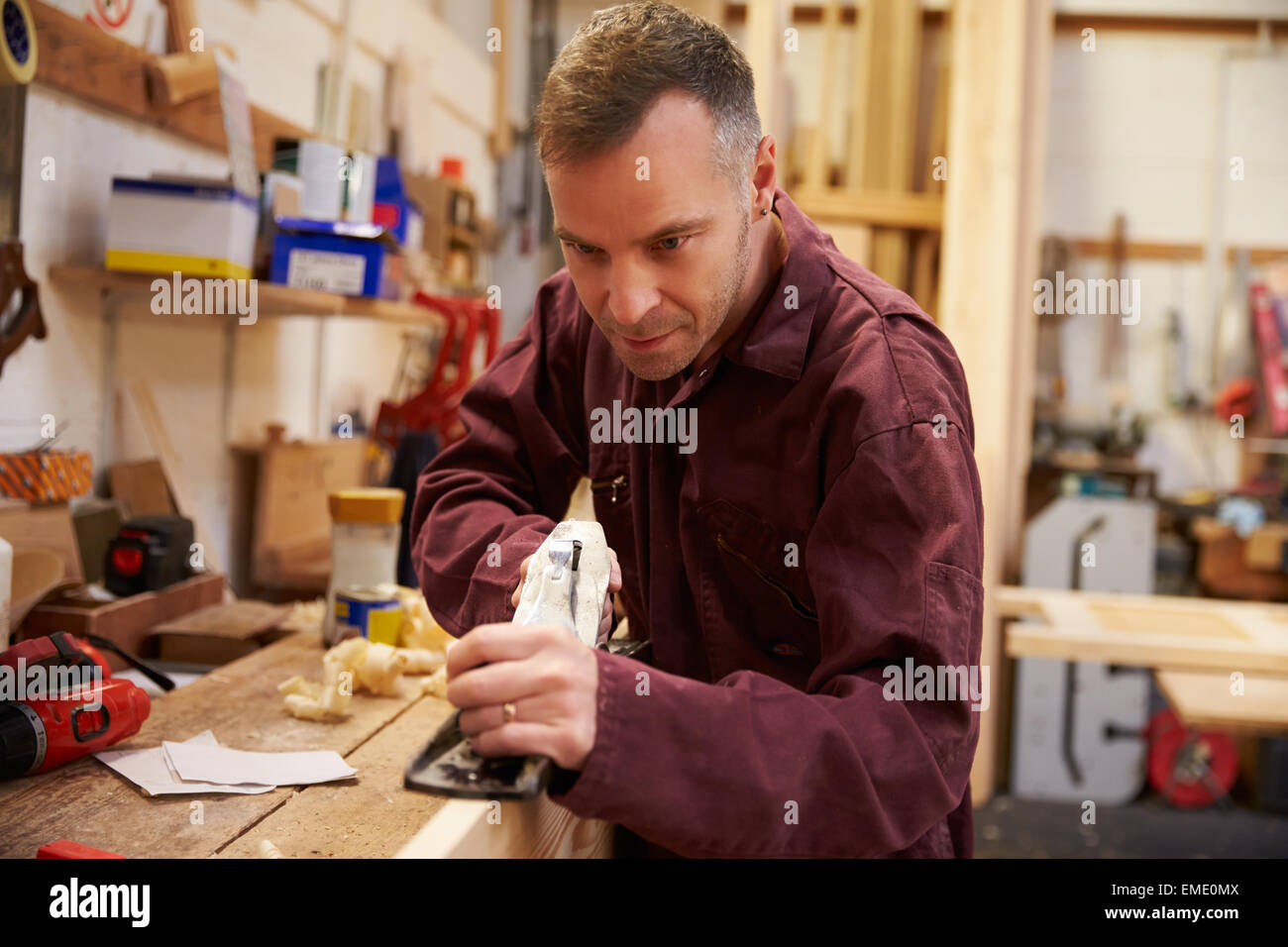 Carpenter Planing Wood In Workshop Stock Photo - Alamy