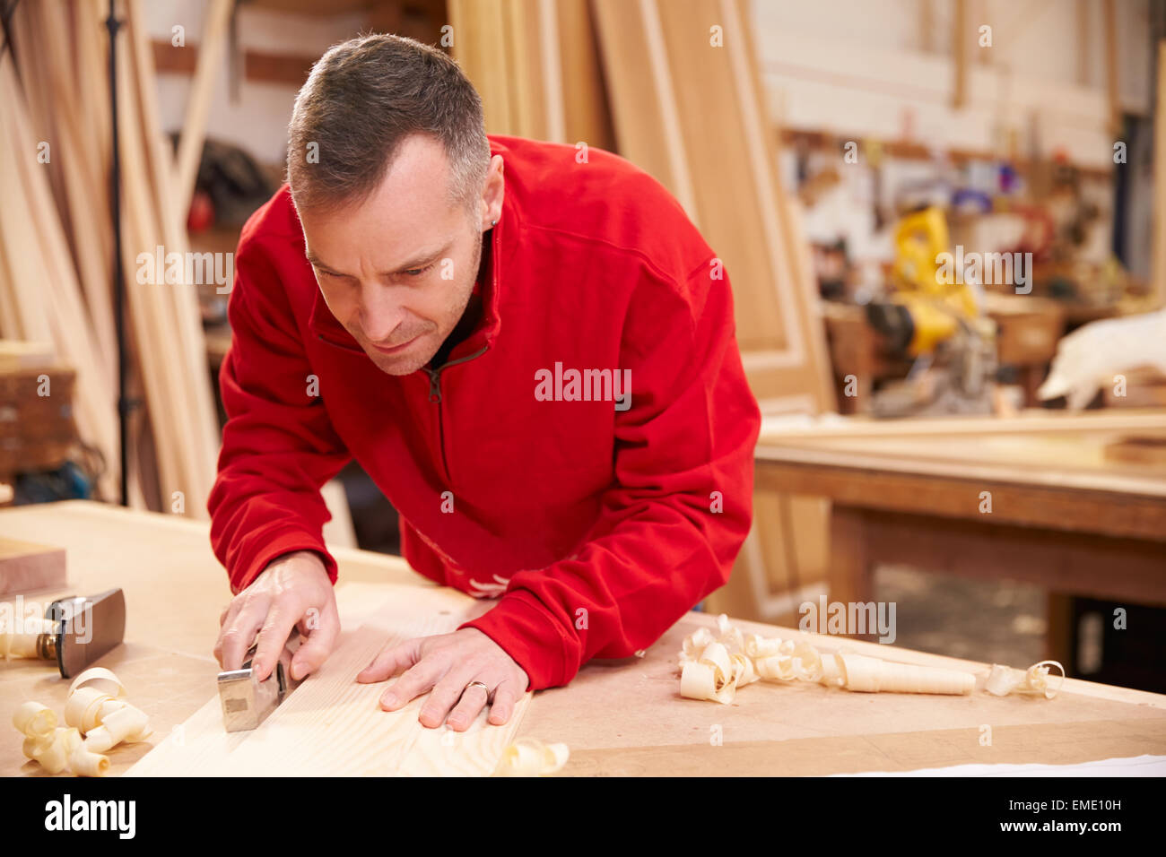 Carpenter Planing Wood In Workshop Stock Photo - Alamy
