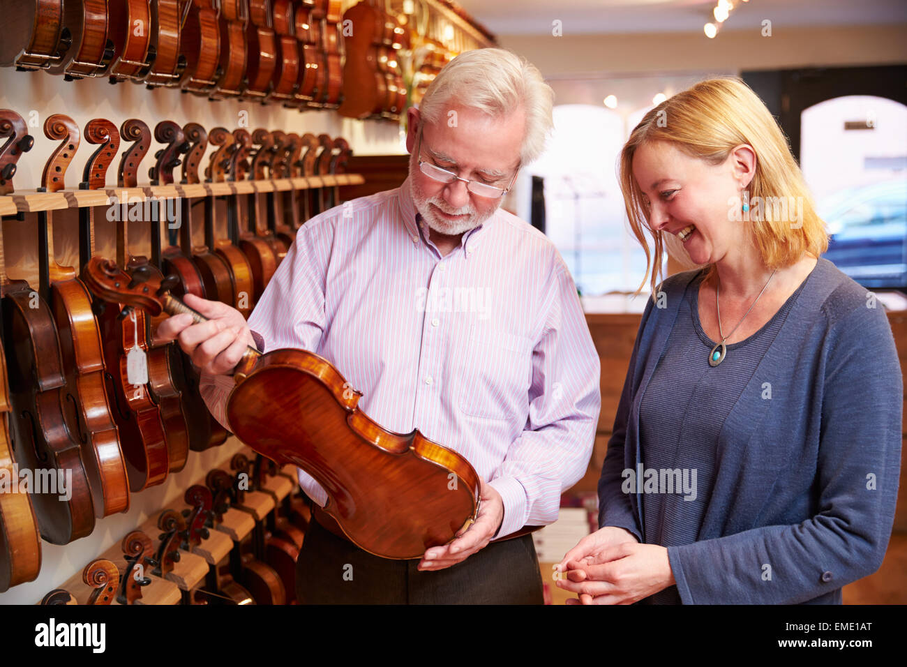 Salesman Advising Customer Buying Violin Stock Photo - Alamy