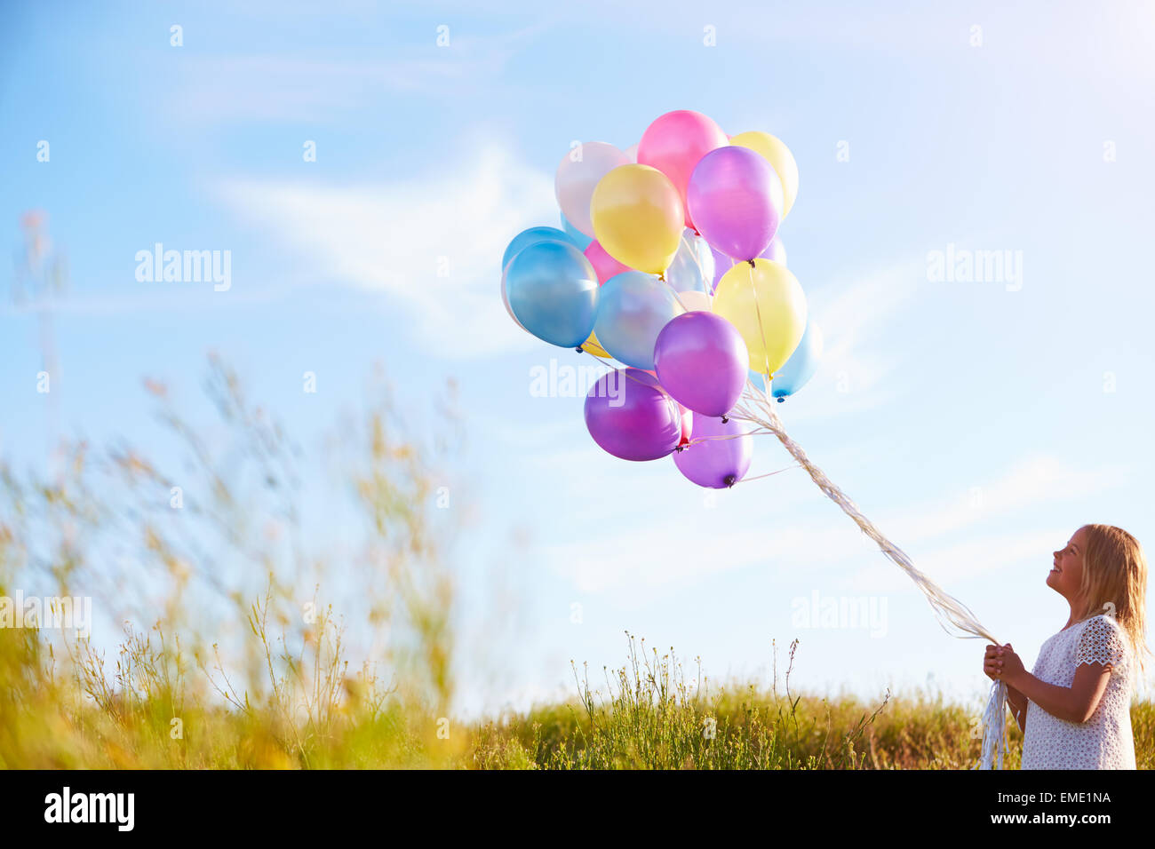 Two Young Girls Holding Bunch Of Colorful Balloons Outdoors Stock Photo ...