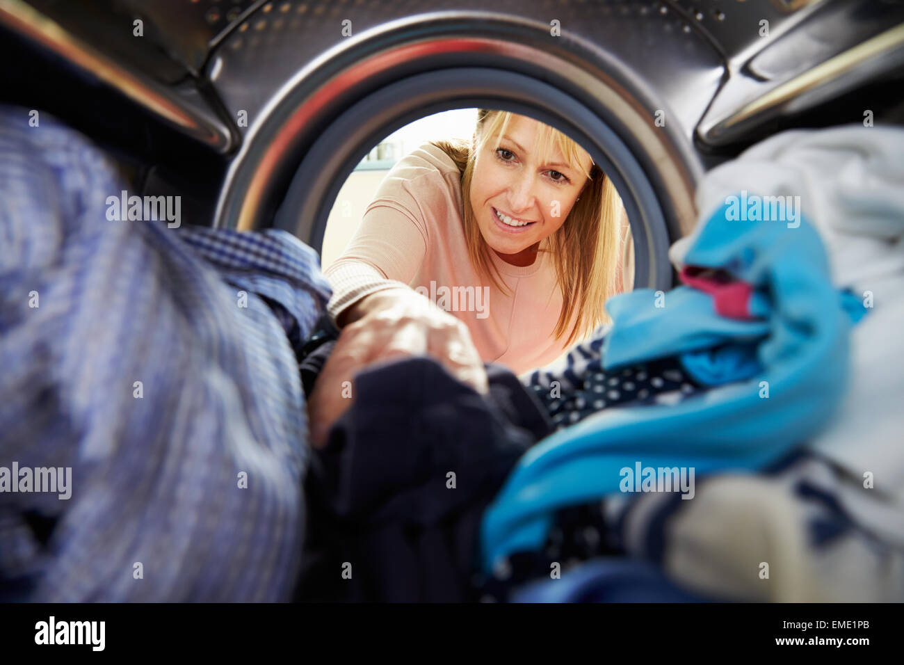Woman Doing Laundry Reaching Inside Washing Machine Stock Photo - Alamy