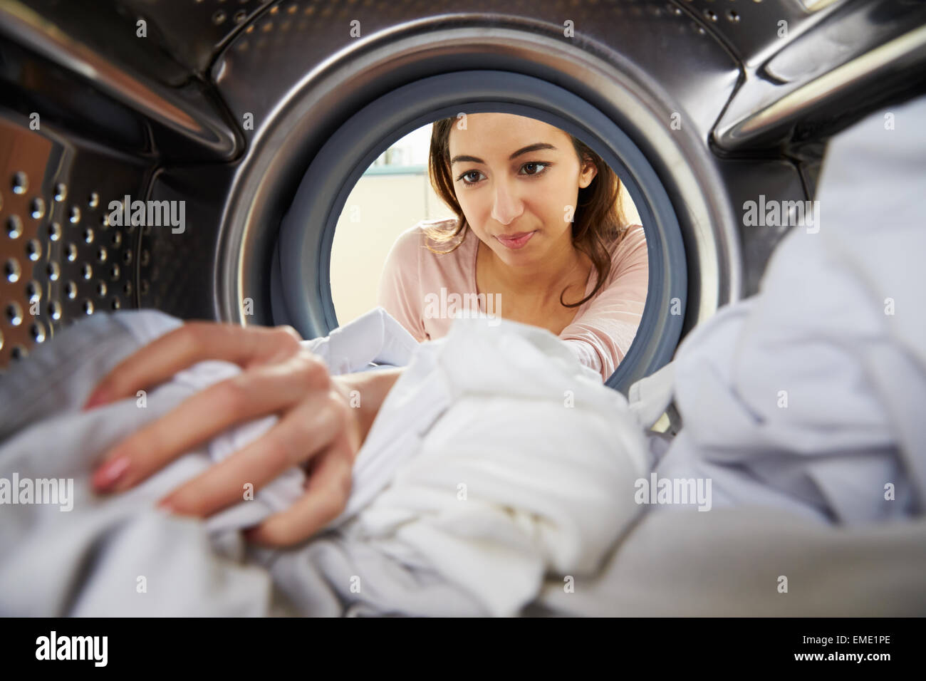 Woman Doing Laundry Reaching Inside Washing Machine Stock Photo - Alamy