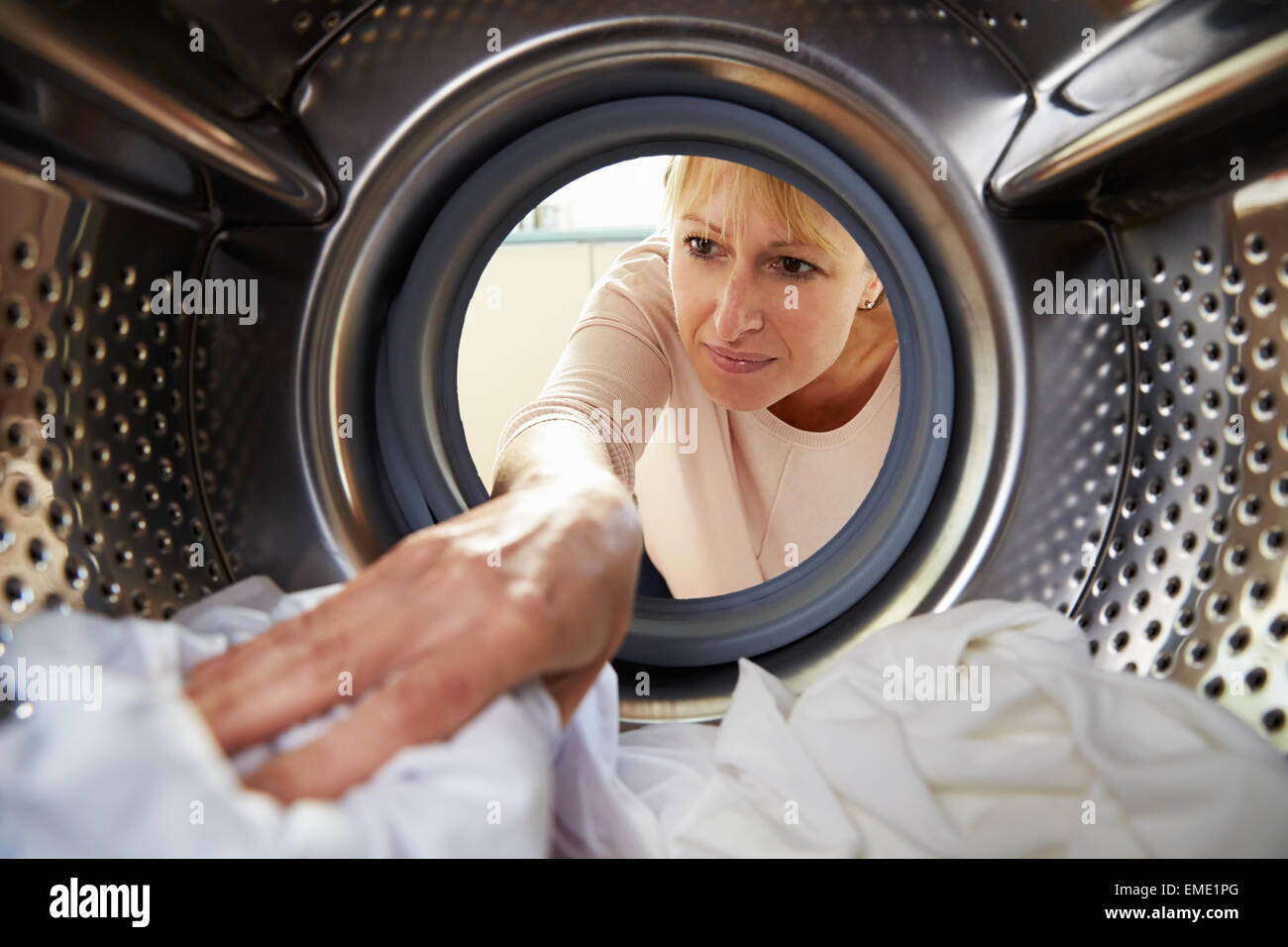 Woman Doing Laundry Reaching Inside Washing Machine Stock Photo - Alamy