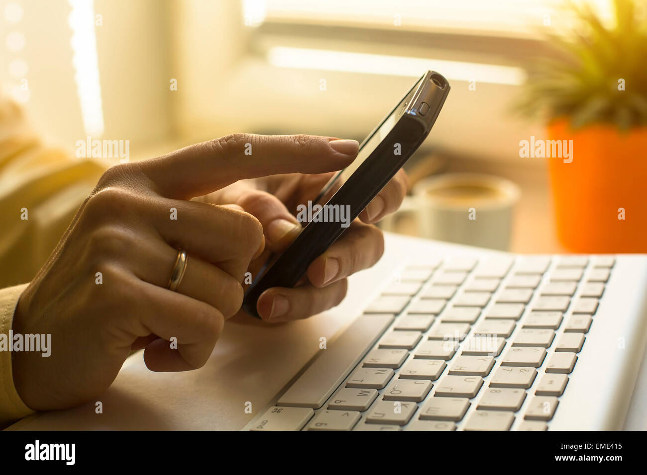Finger touches the smartphone, keyboard and coffee in background Stock ...