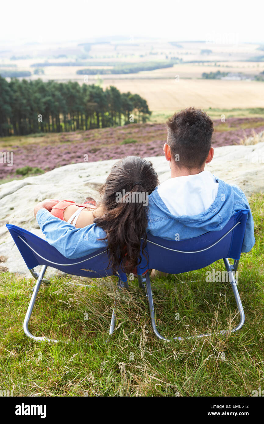 Young Couple Sitting In Chairs On Camping Trip Stock Photo - Alamy